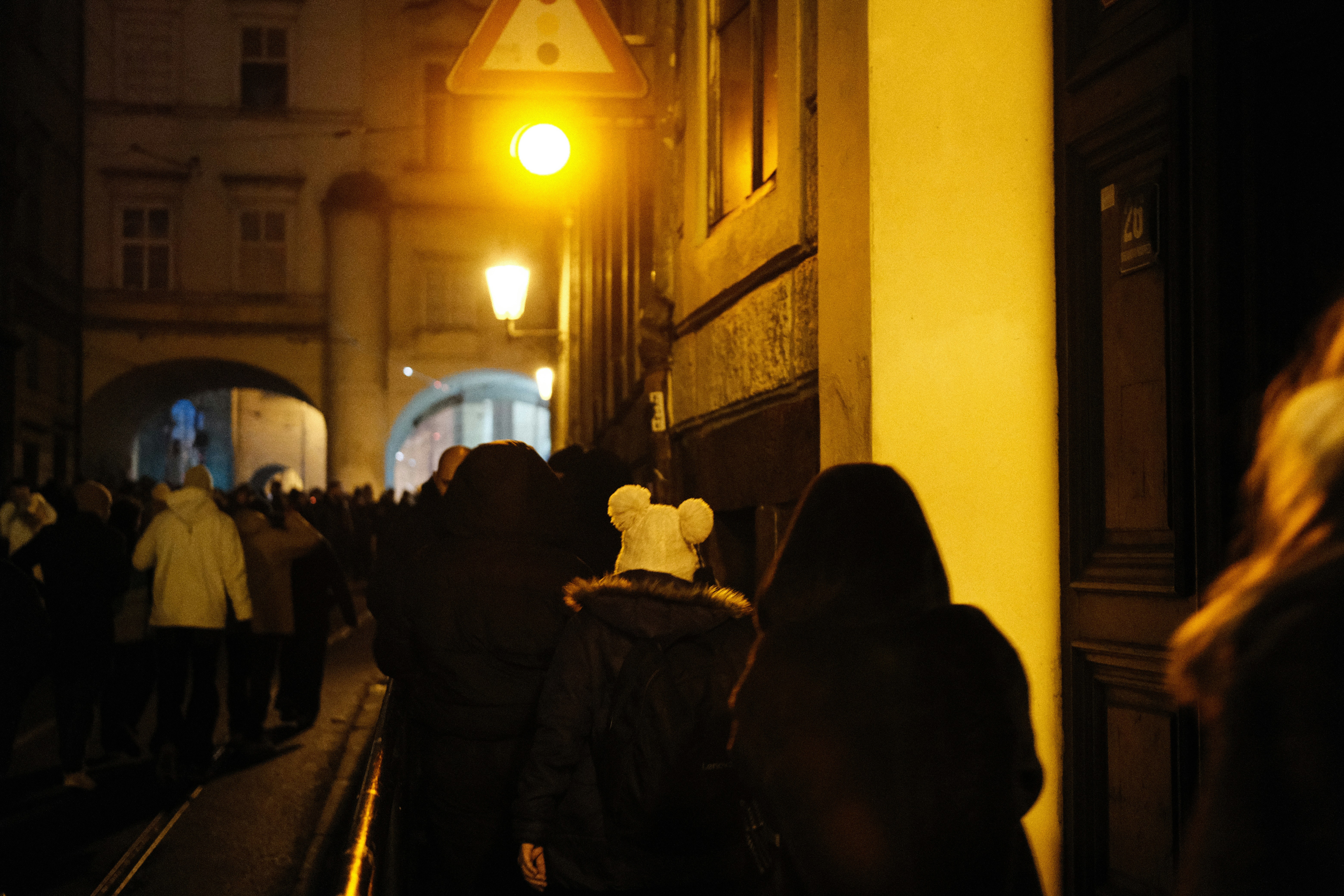 People walking in a narrow street at night