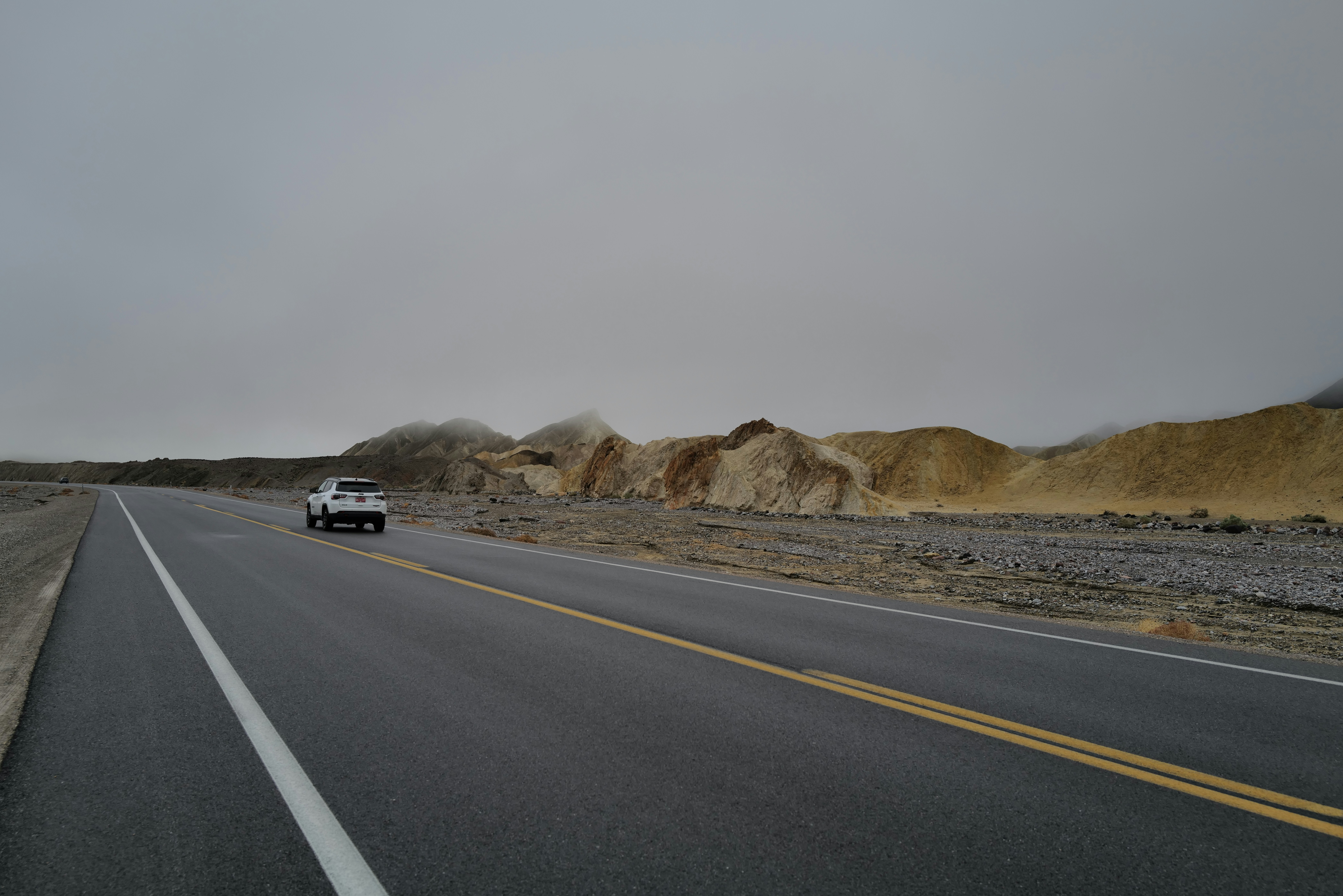 Desert Highway Quiet: A White Car on a Lone Canyon Road