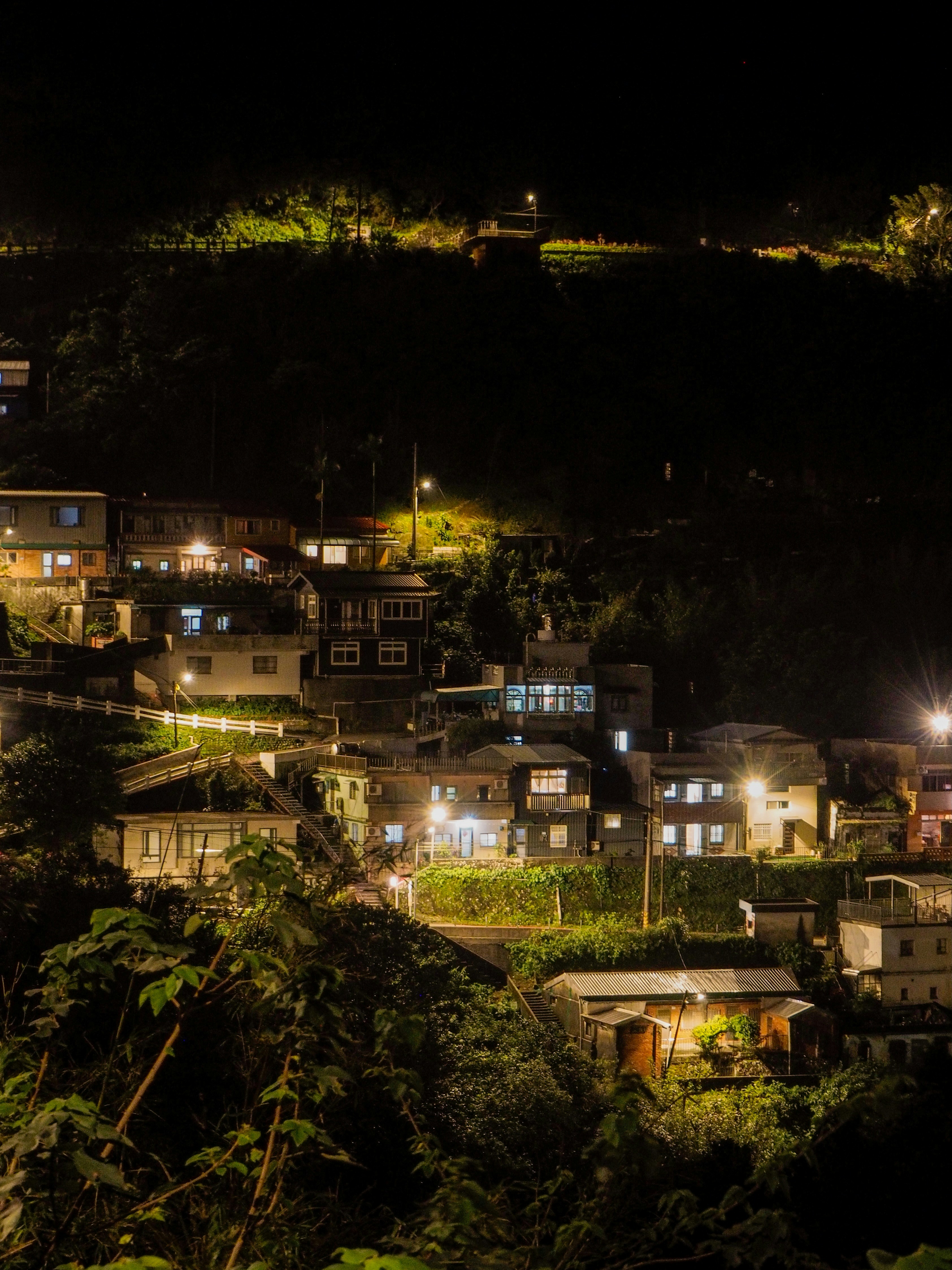 Night village lights tracing a hillside labyrinth