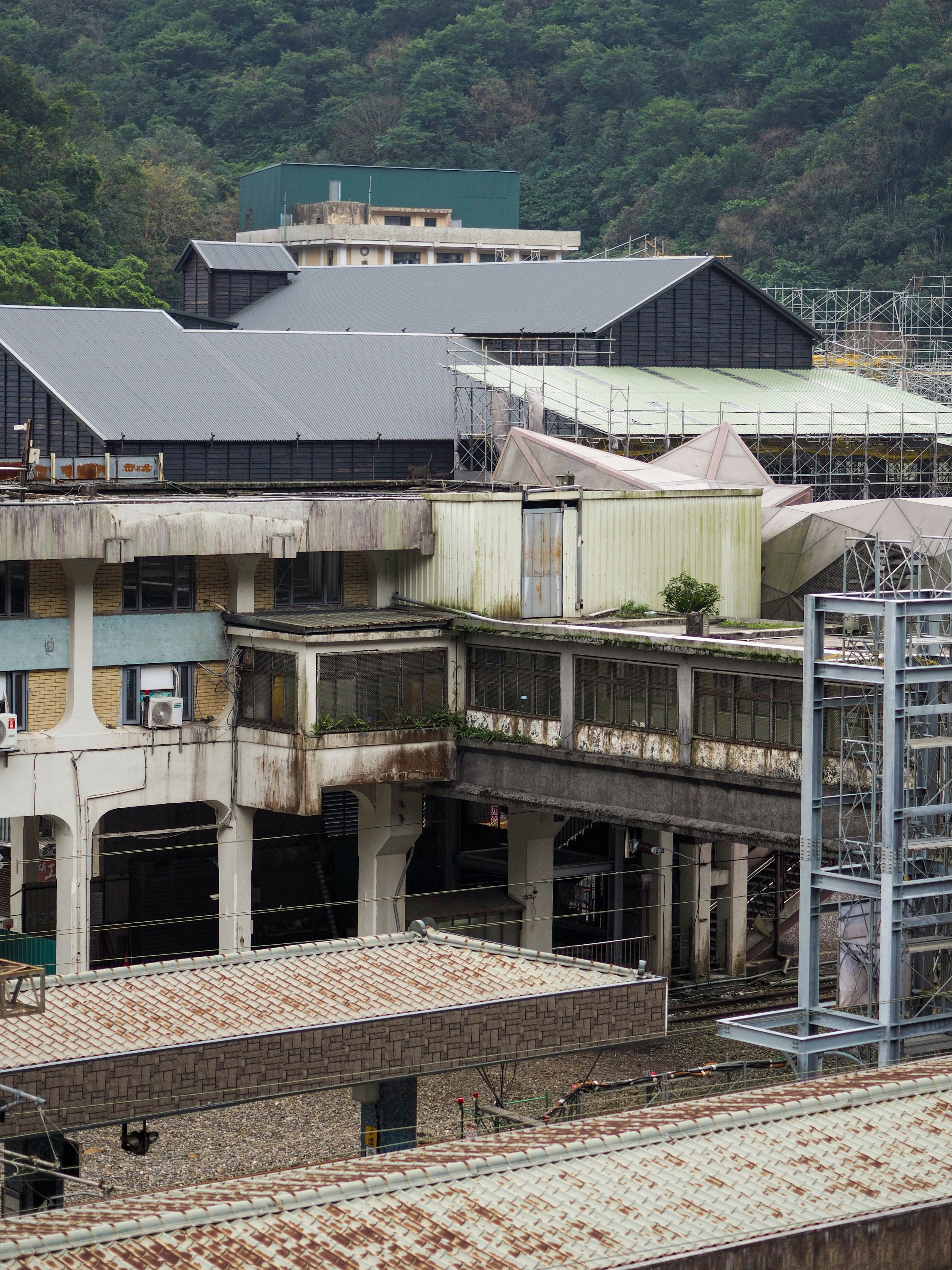 Abandoned Factory Facade Framed by Distant Green Hills