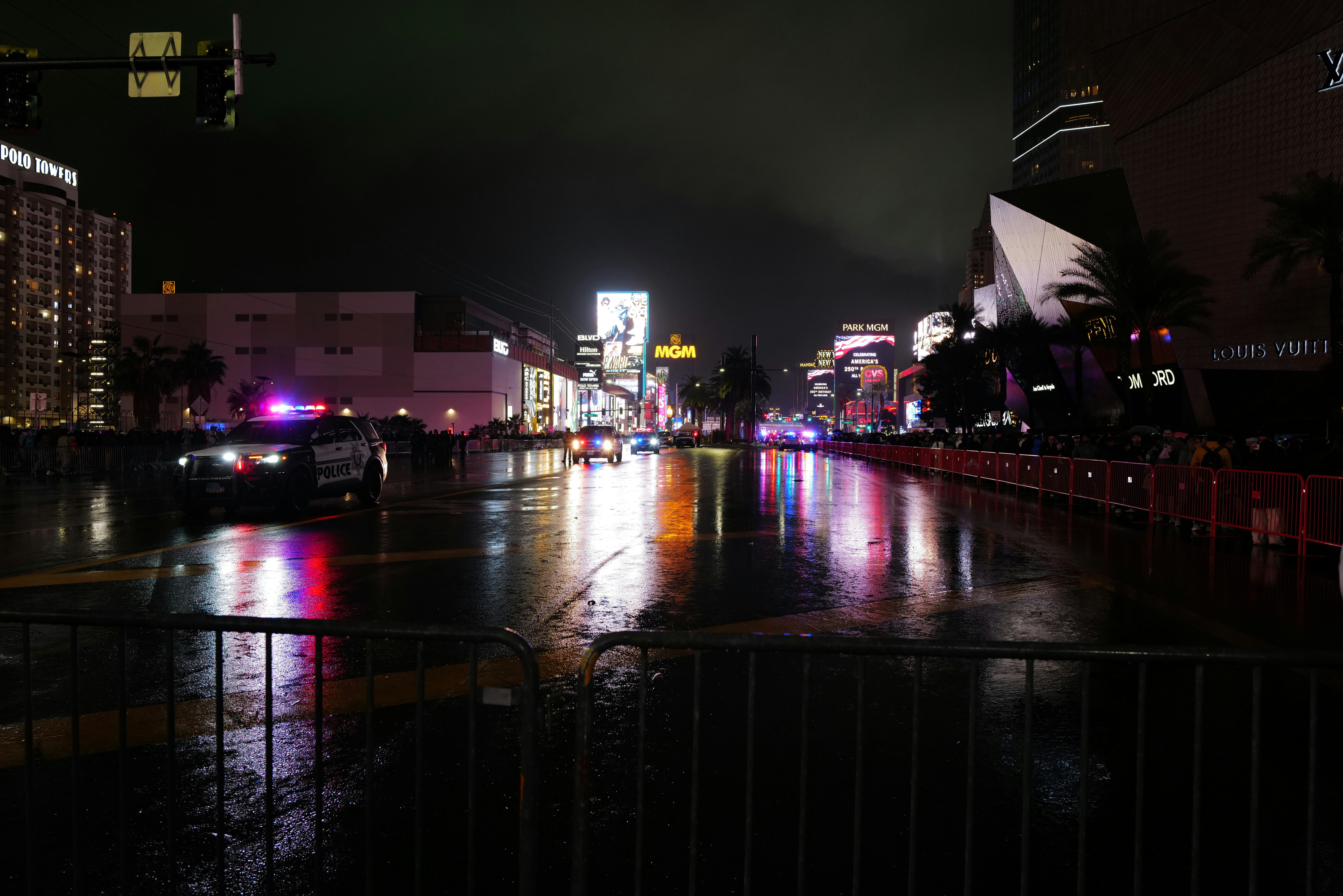 Wet city street at night with flashing police lights