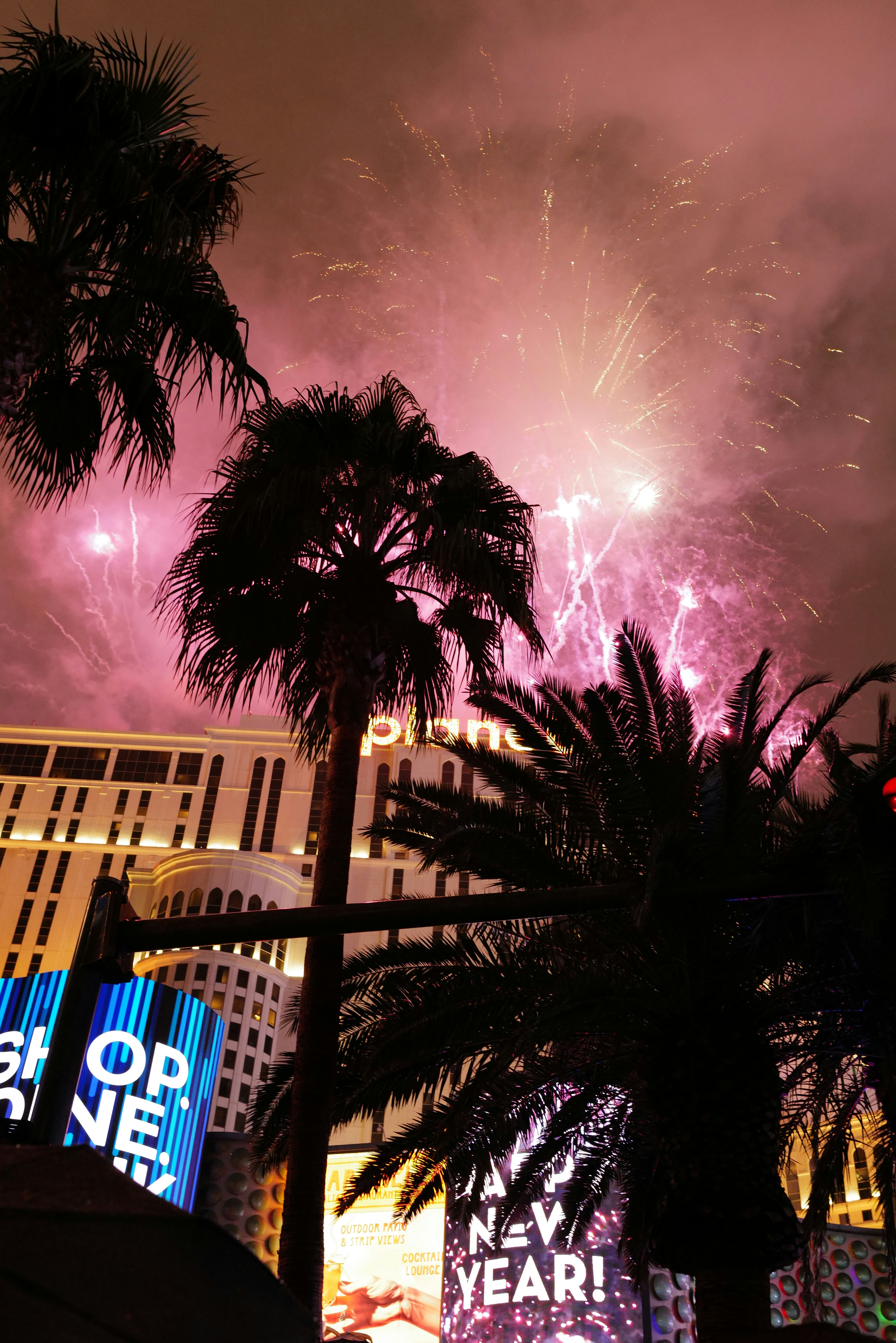 Fireworks over a Neon-lit Hotel at Midnight