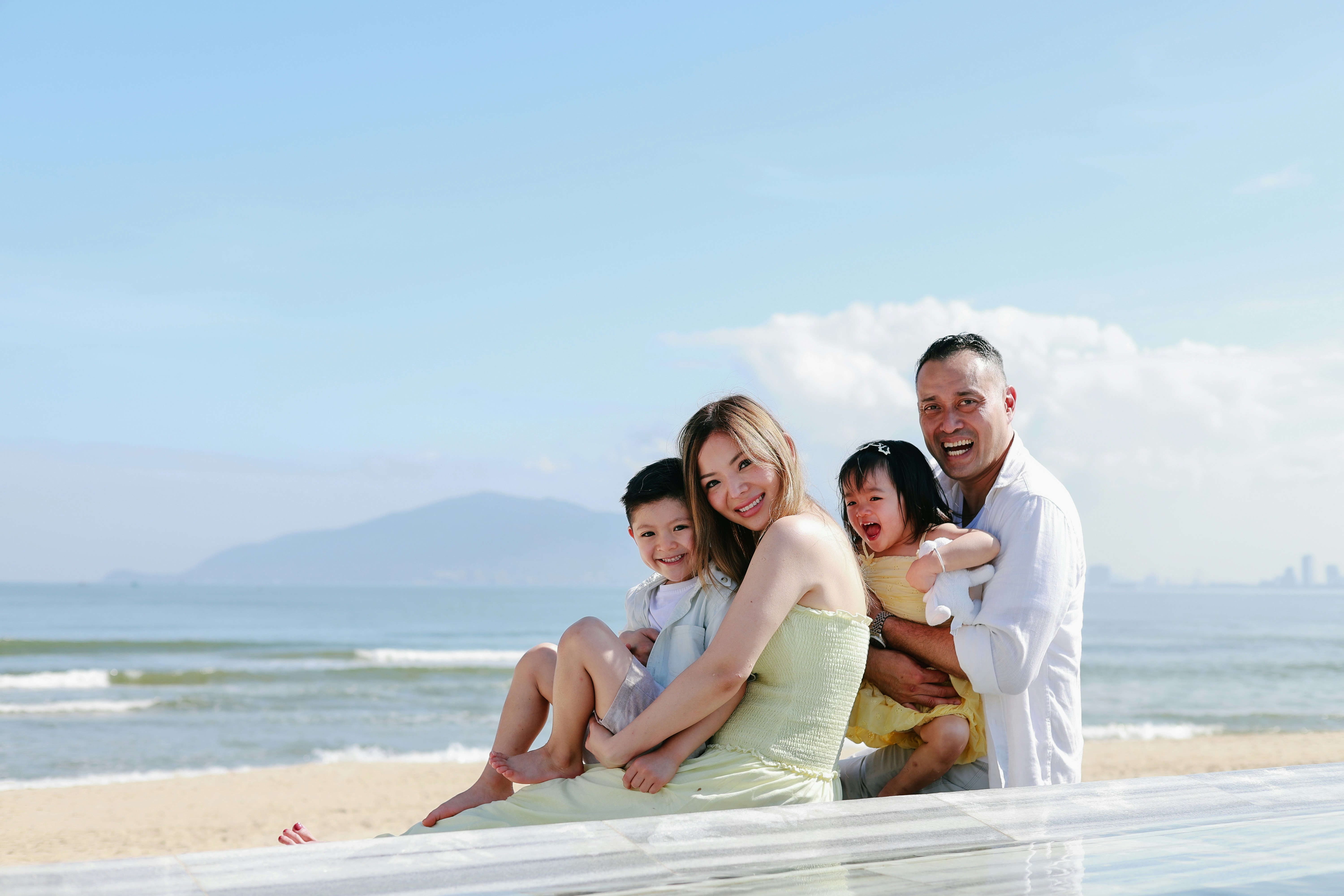 Sunlit family embrace on a breezy beach