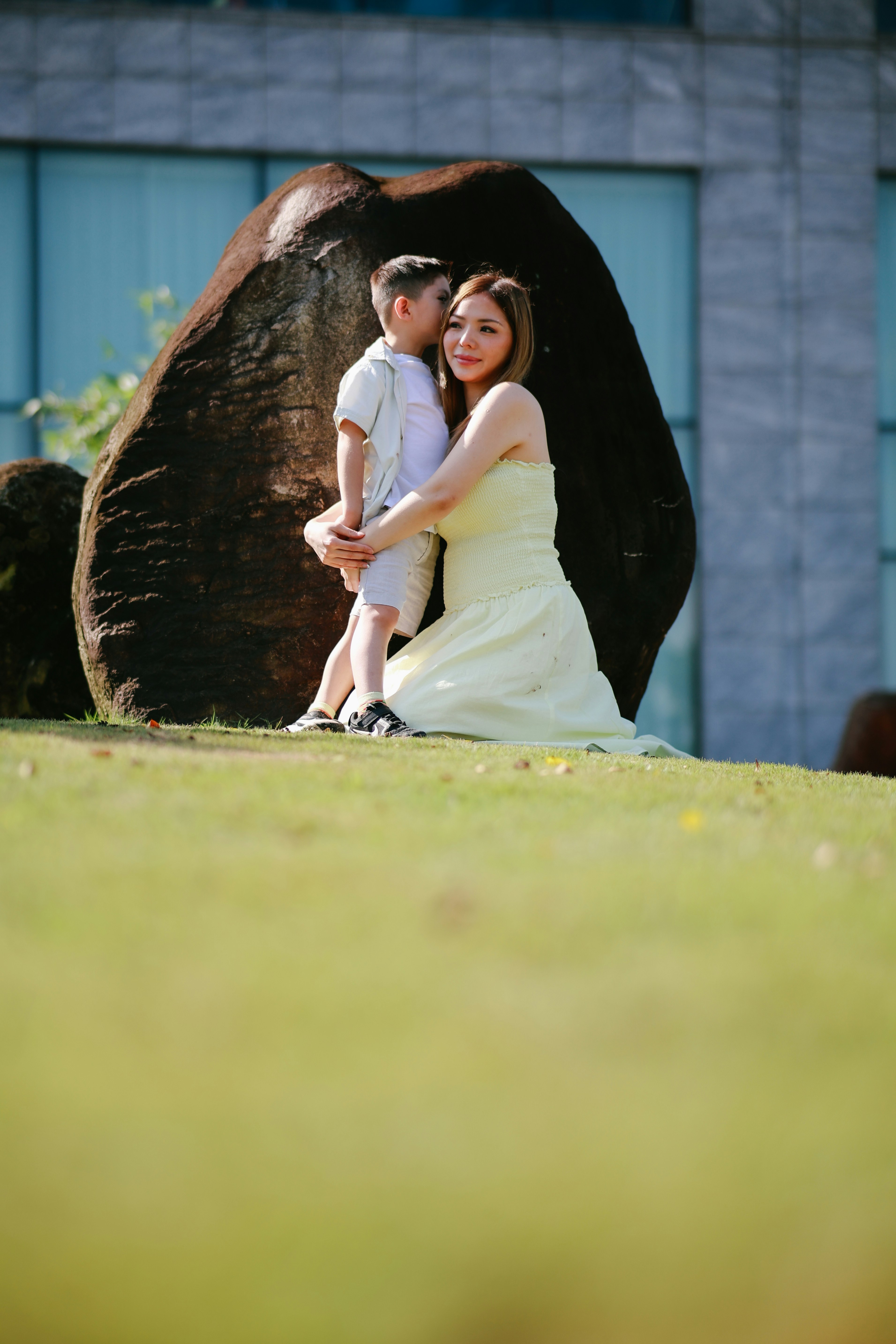 Mother and Child Share a Tender Moment by the Stone Backdrop