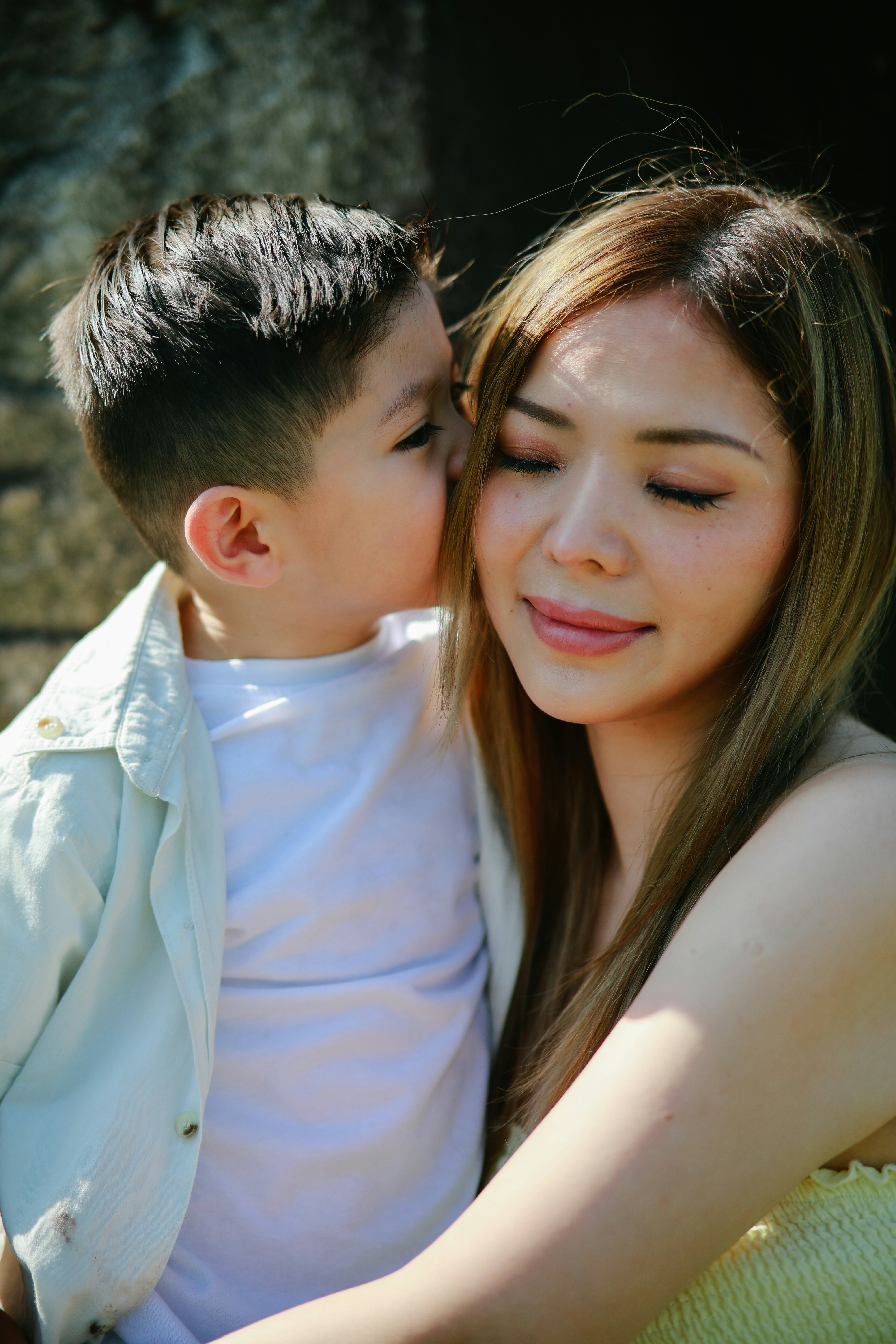 Affection in Sunlit Silence: A Mother and Child Share a Gentle Moment
