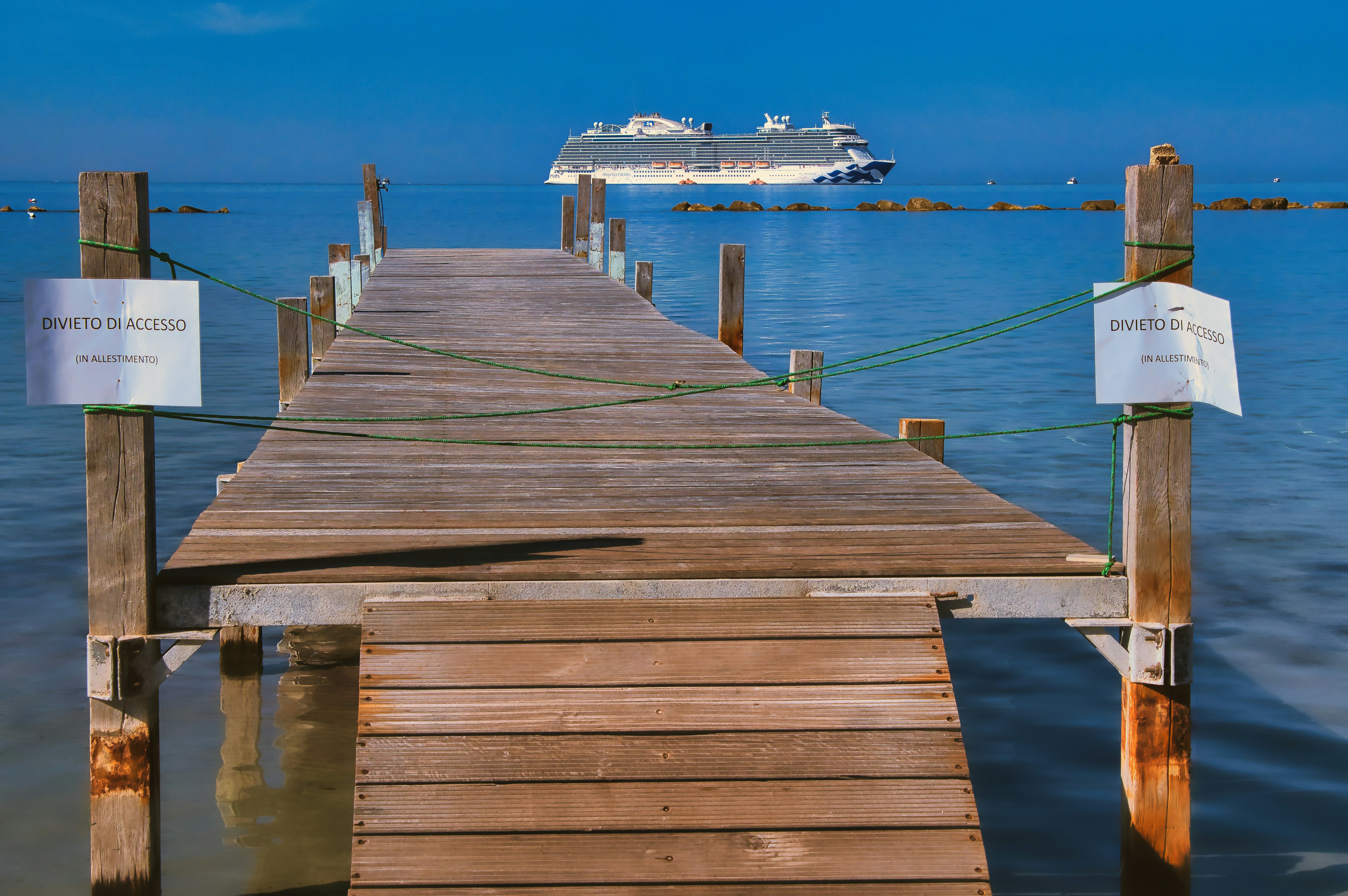 Pier Extension: A Wooden Path to a Distant Cruise in Calm Seas