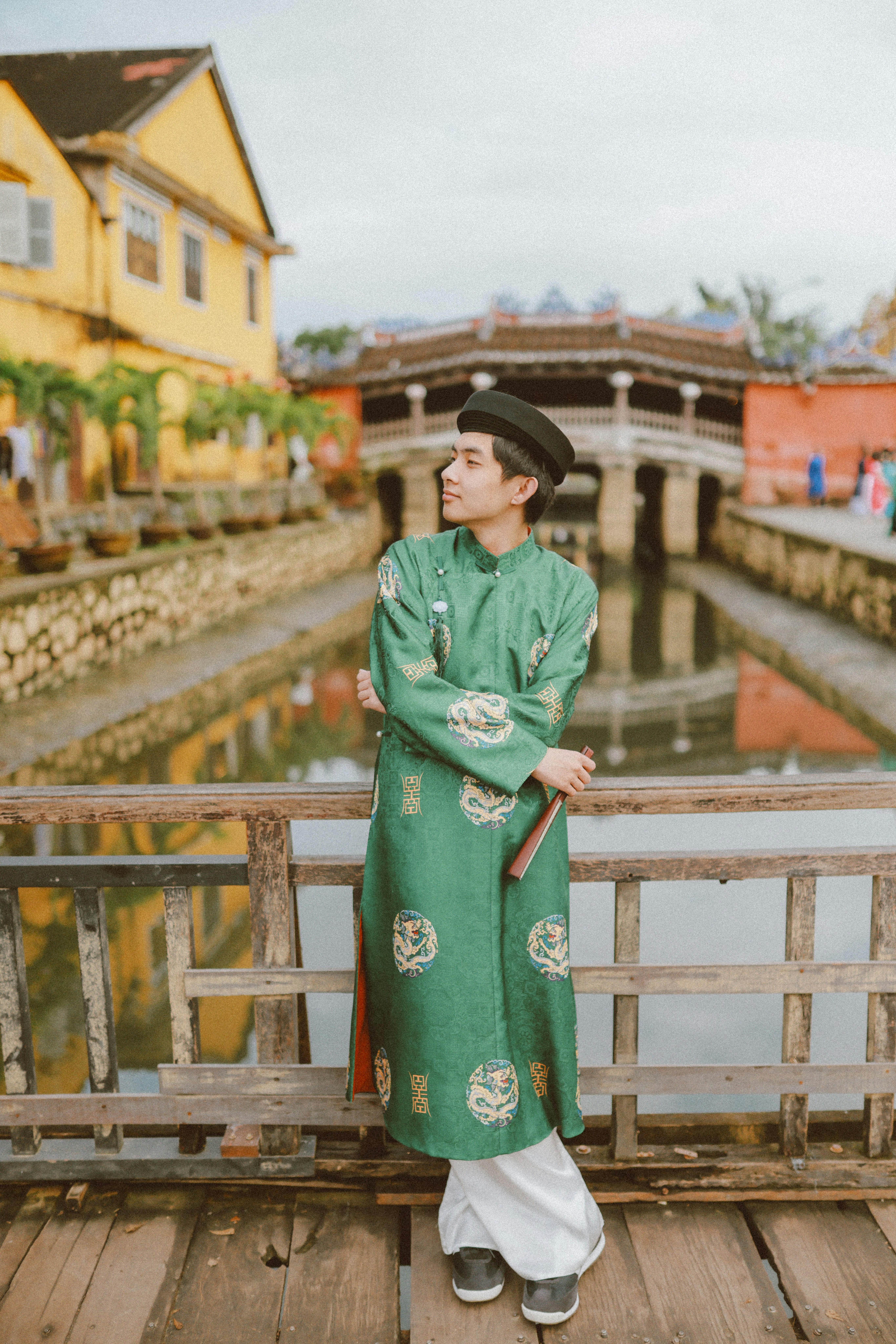 Green áo dài in a riverside village portrait