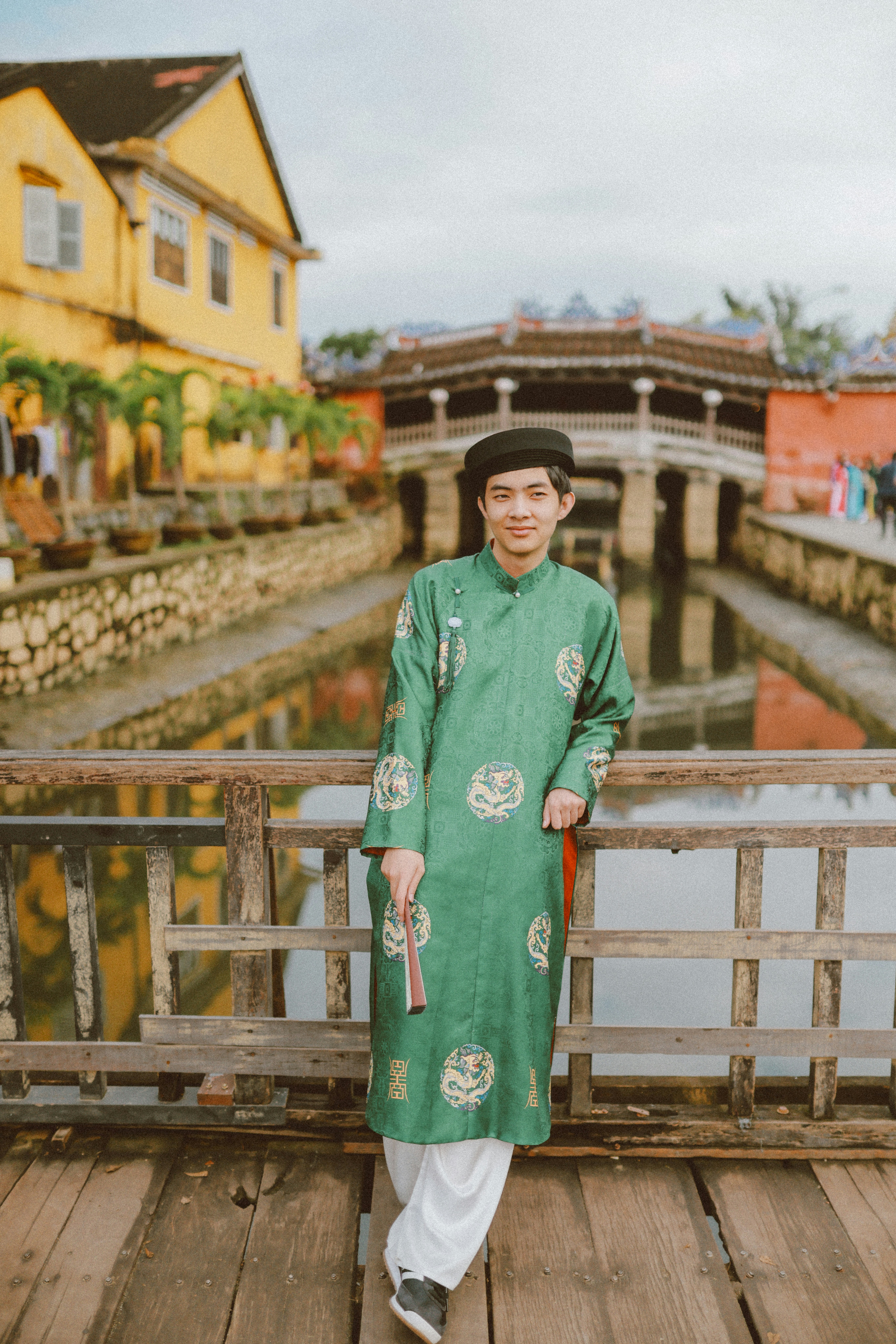 Green Áo dài on the Bridge: Traditional Attire Amid Riverside Village