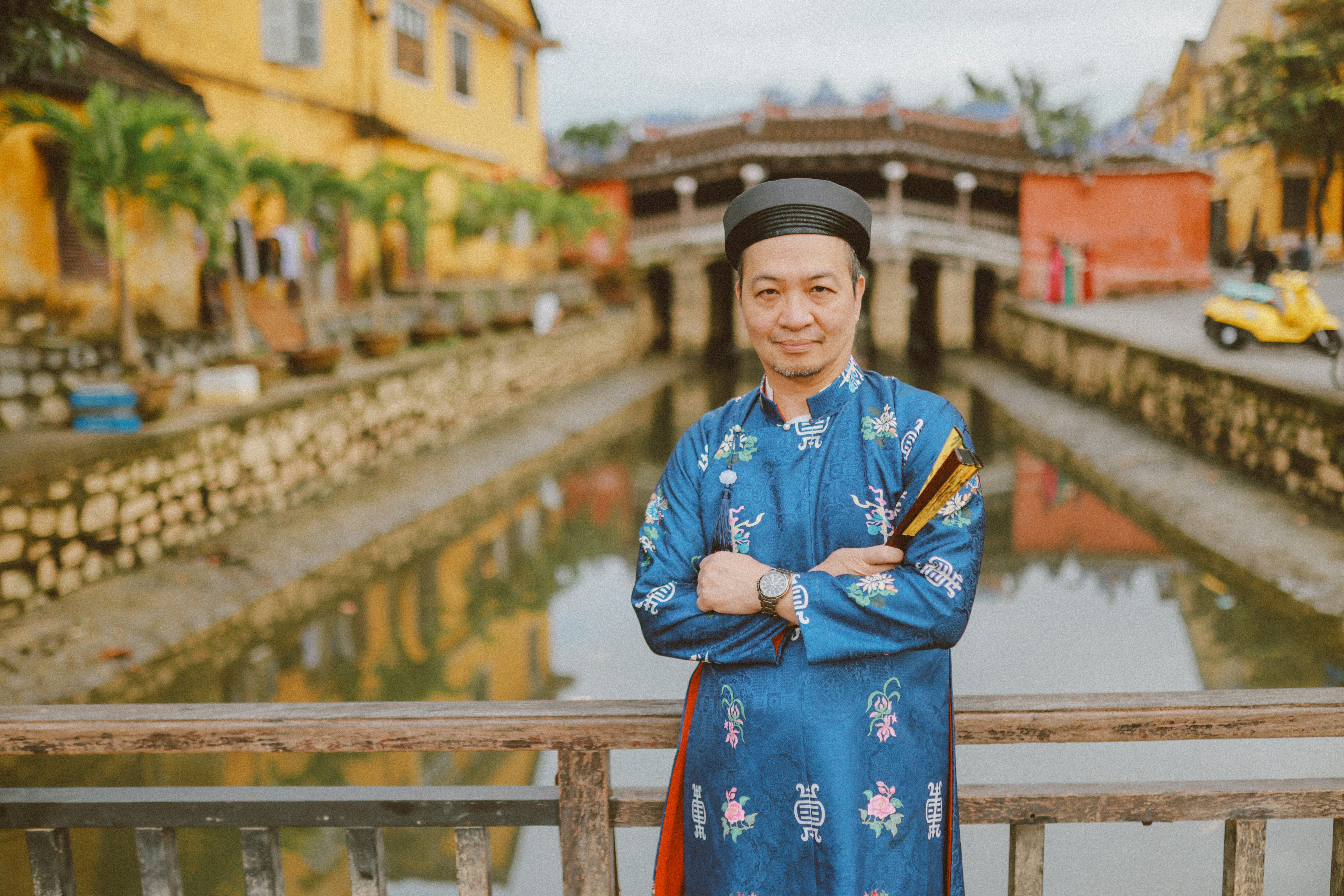Blue robe and calm gaze: a crossing of tradition by the canal