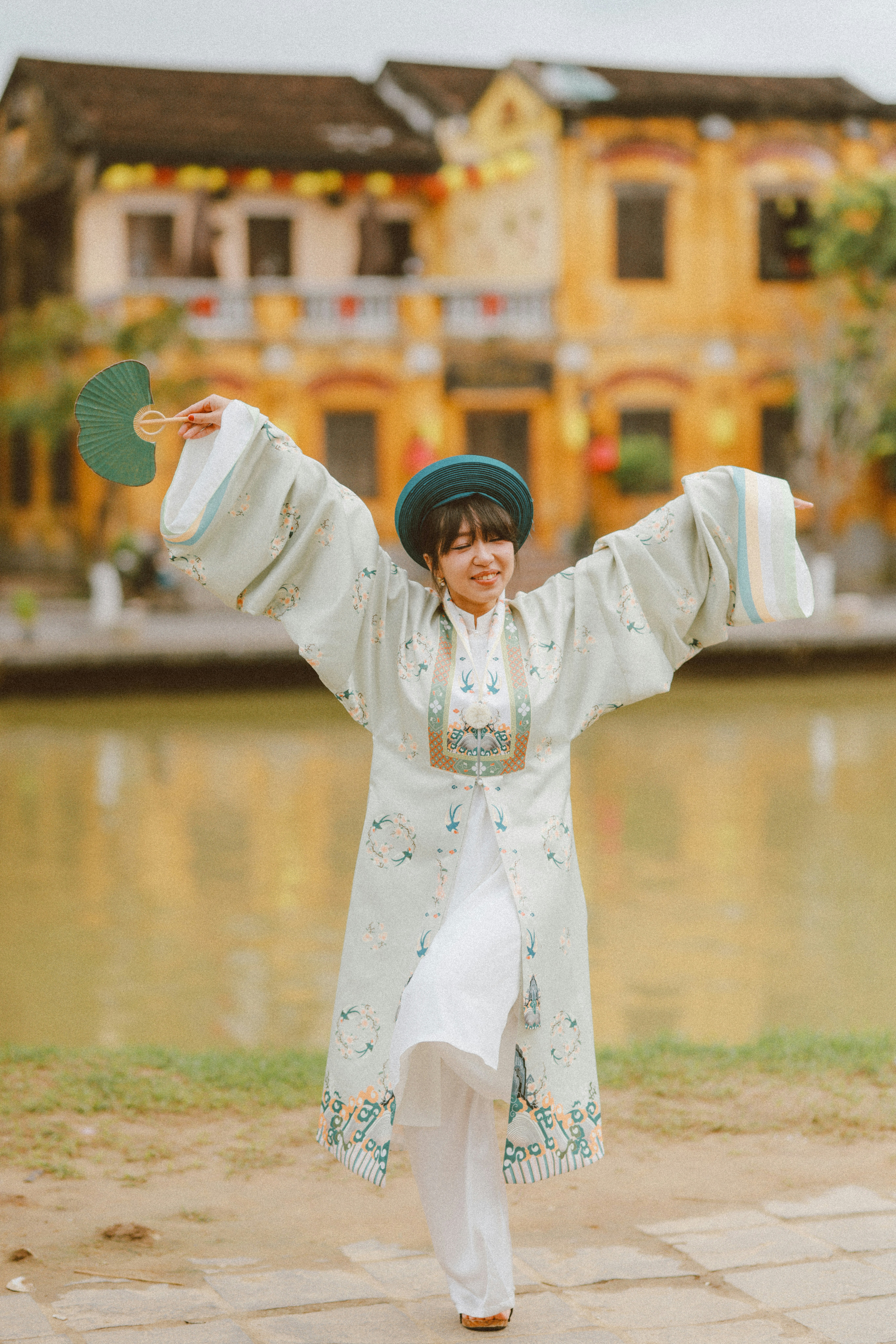 Graceful dancer in a traditional áo dài by the lakefront