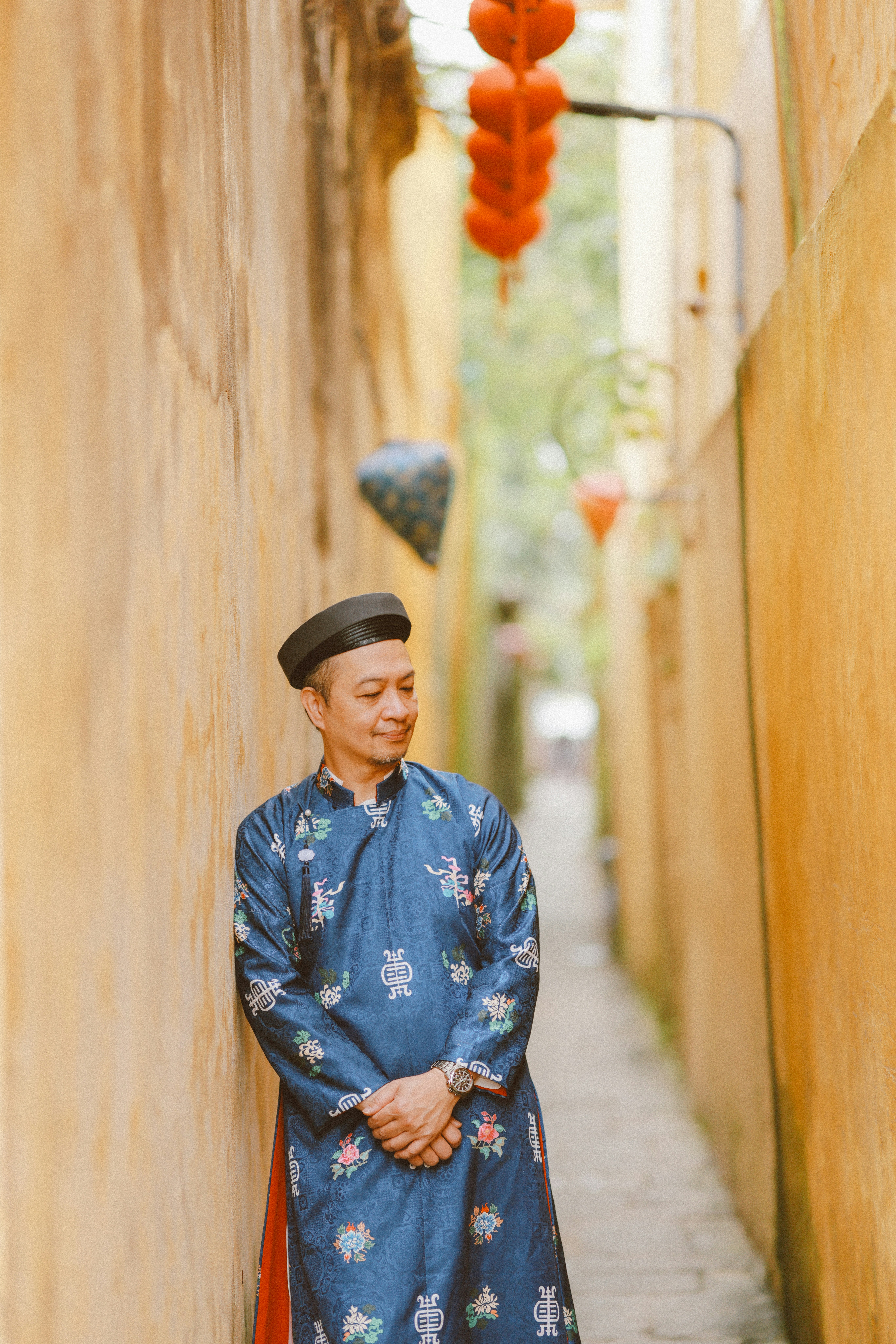 Gentleman in a Blue Silk Robe Stands Quietly in a Narrow Sunset Alley