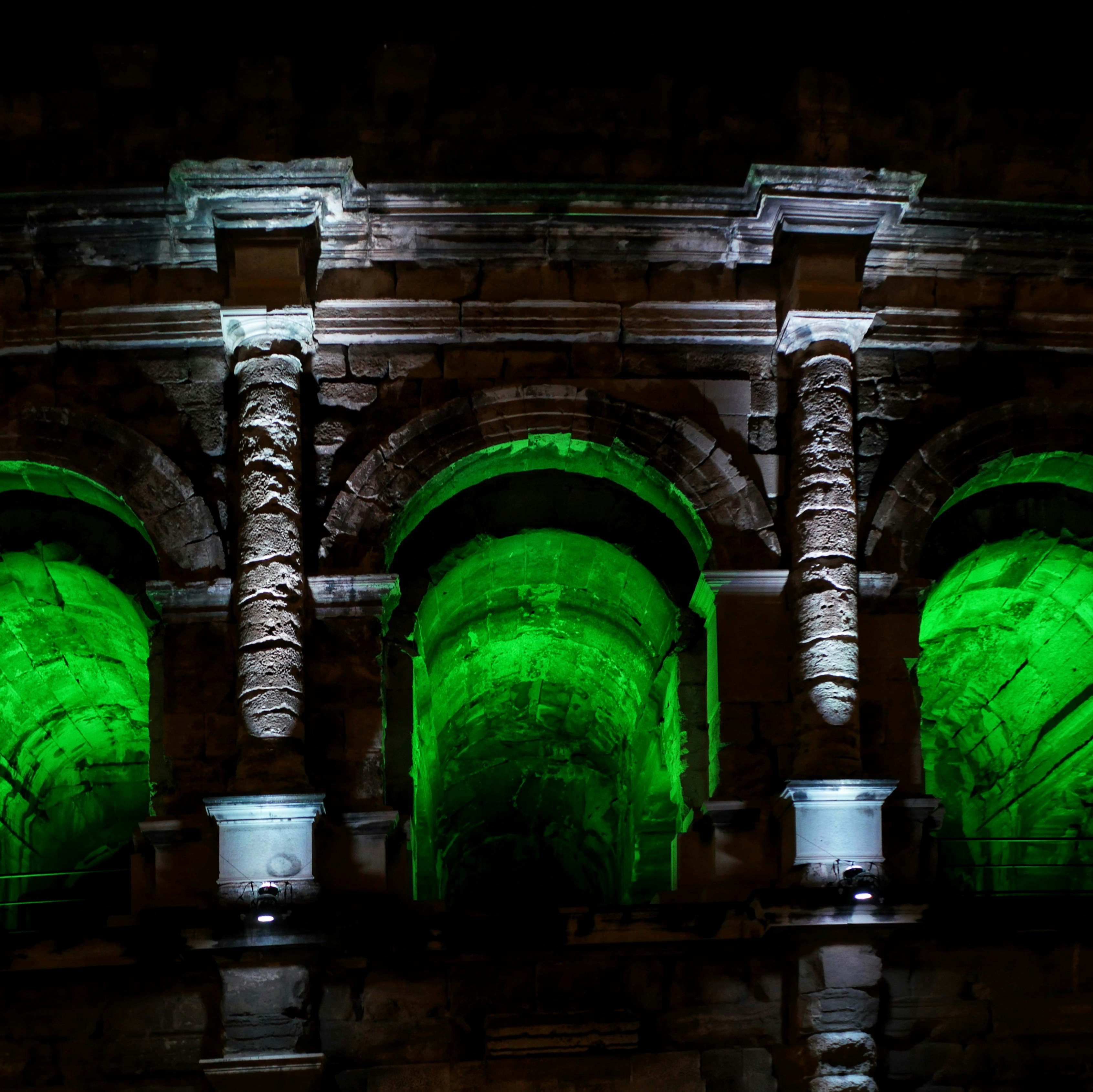 Green Arches Under Night Sky: A Stone Gateway Illuminated