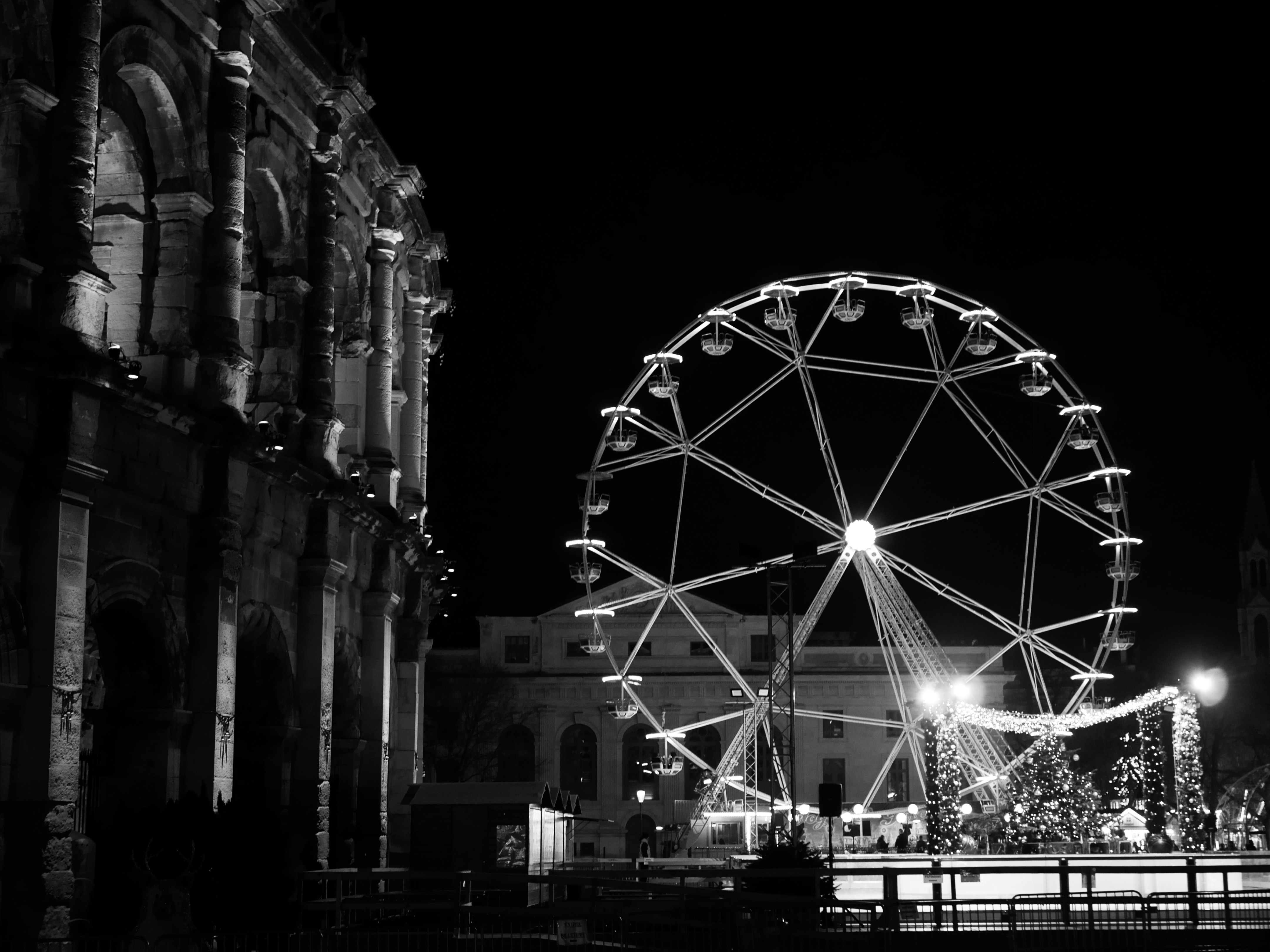Nighttime Ferris Wheel Illumination Over Ancient Arches