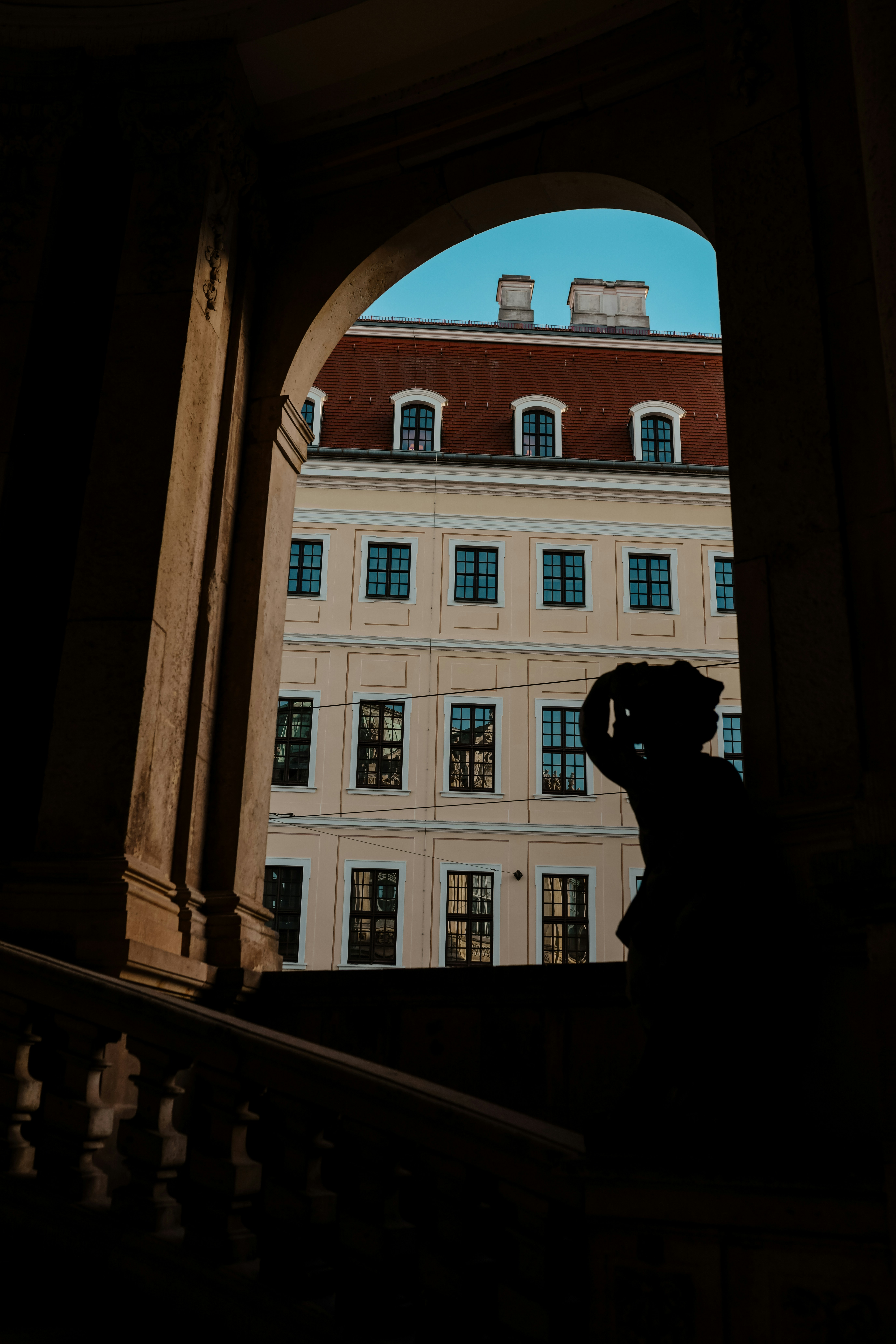Silhouette at the Arch: A Portrait Within a Classical Courtyard