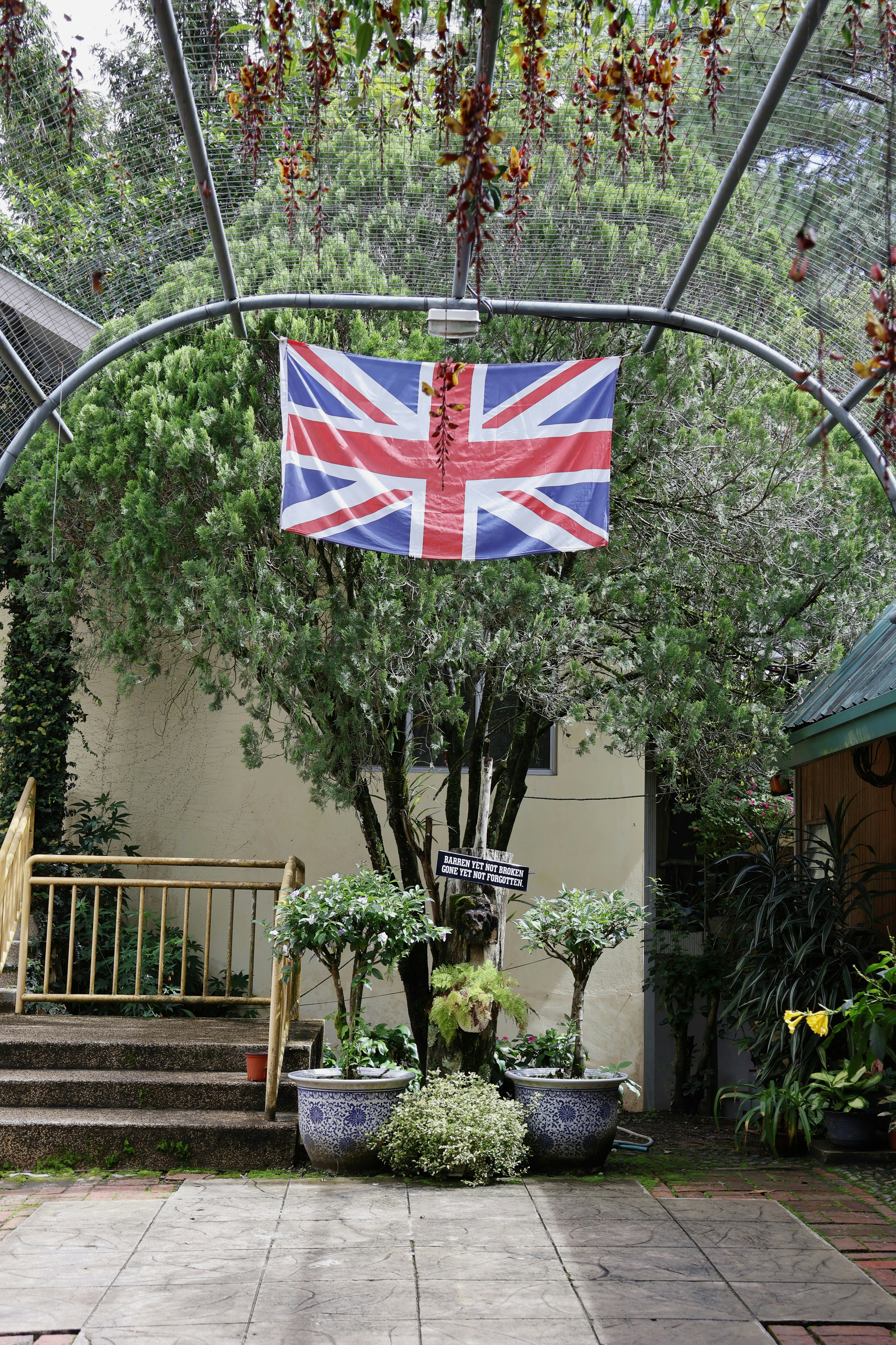 Union Jack under Glass: A Quiet Courtyard Flag Amid Greenery