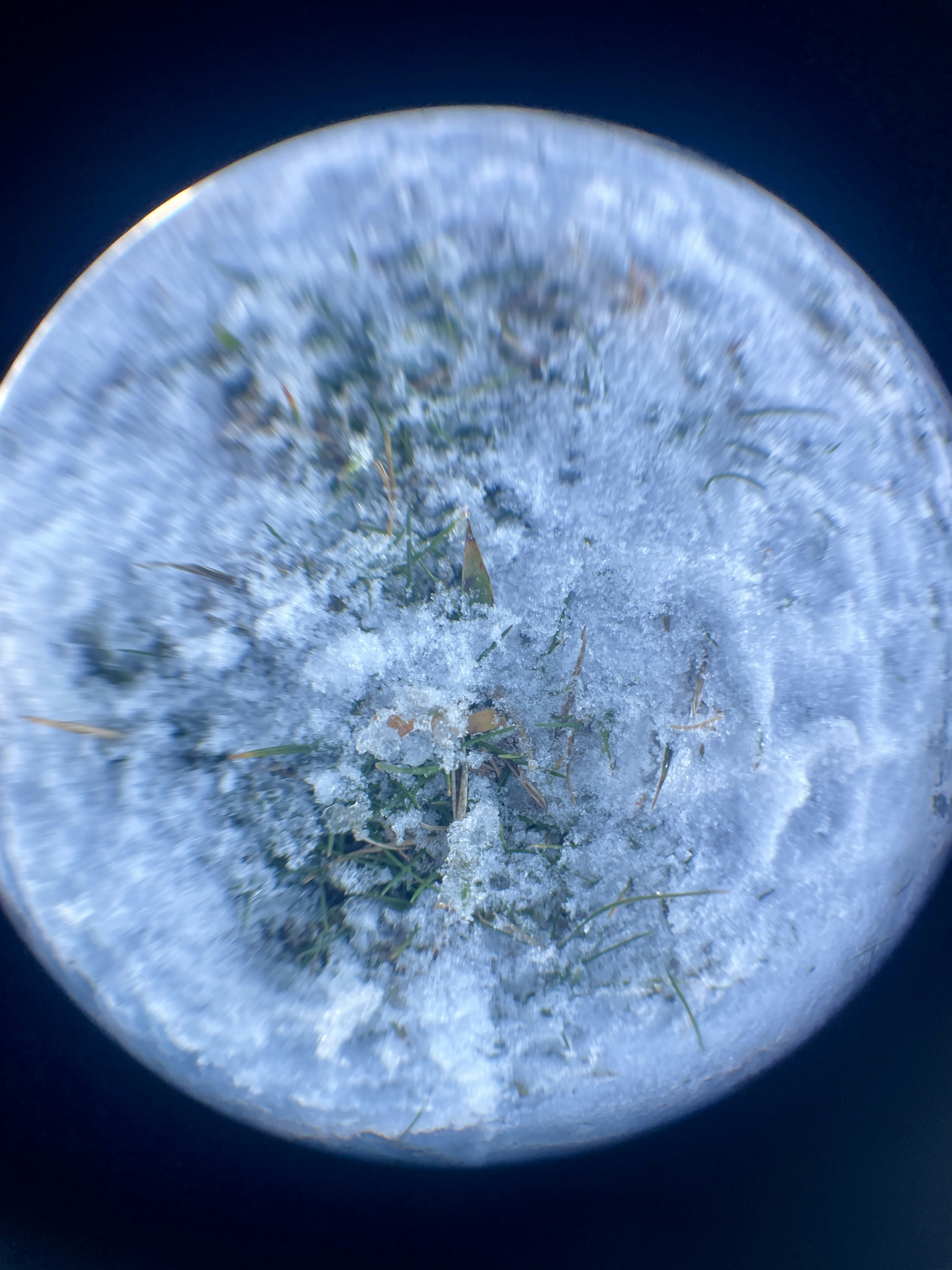 Frosty Lens: Close-up of Ice-crystal Bed under Bright Blue Edge