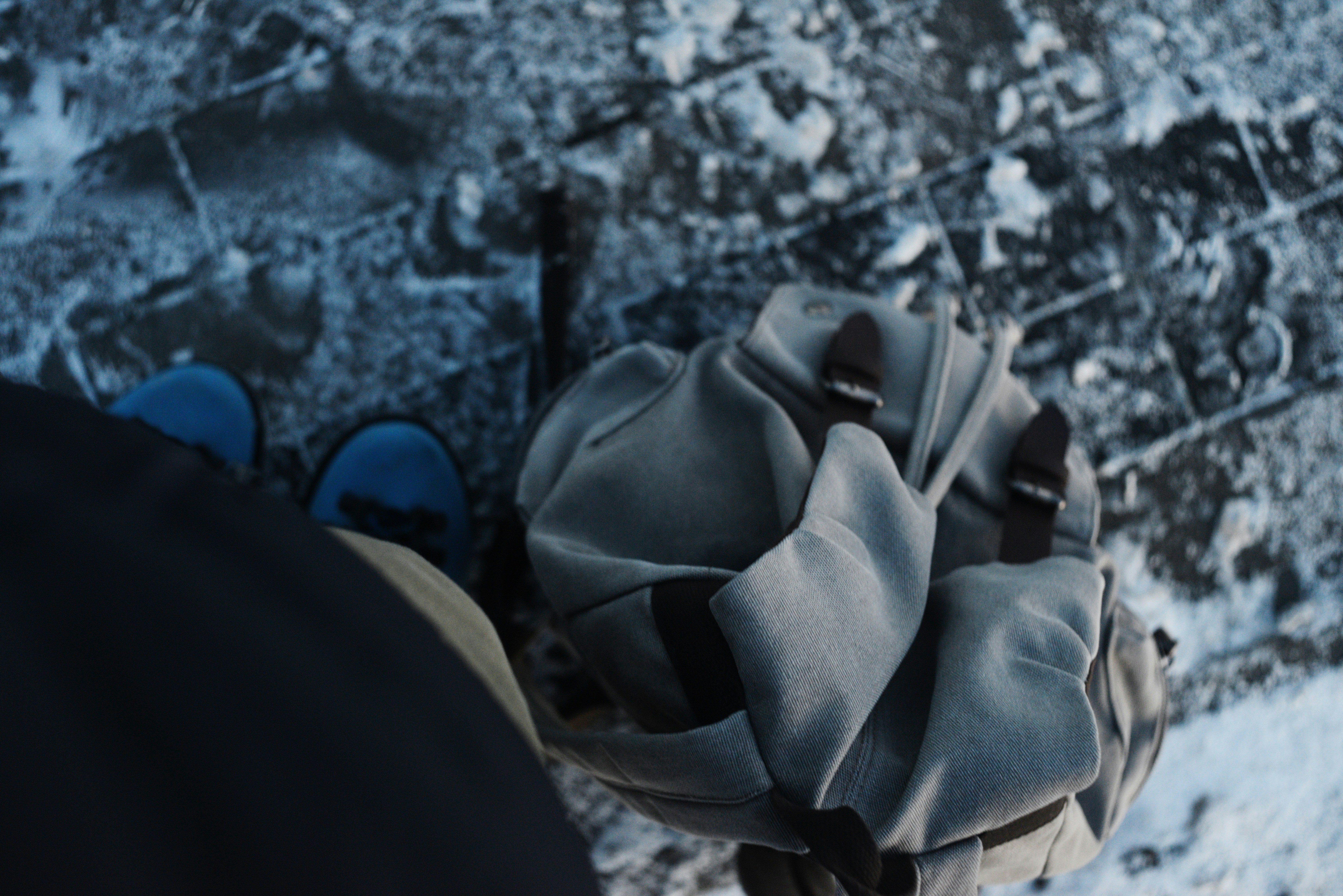 Backpack Pause: Boots, Ground, and Grey Pack on Snowy Trail