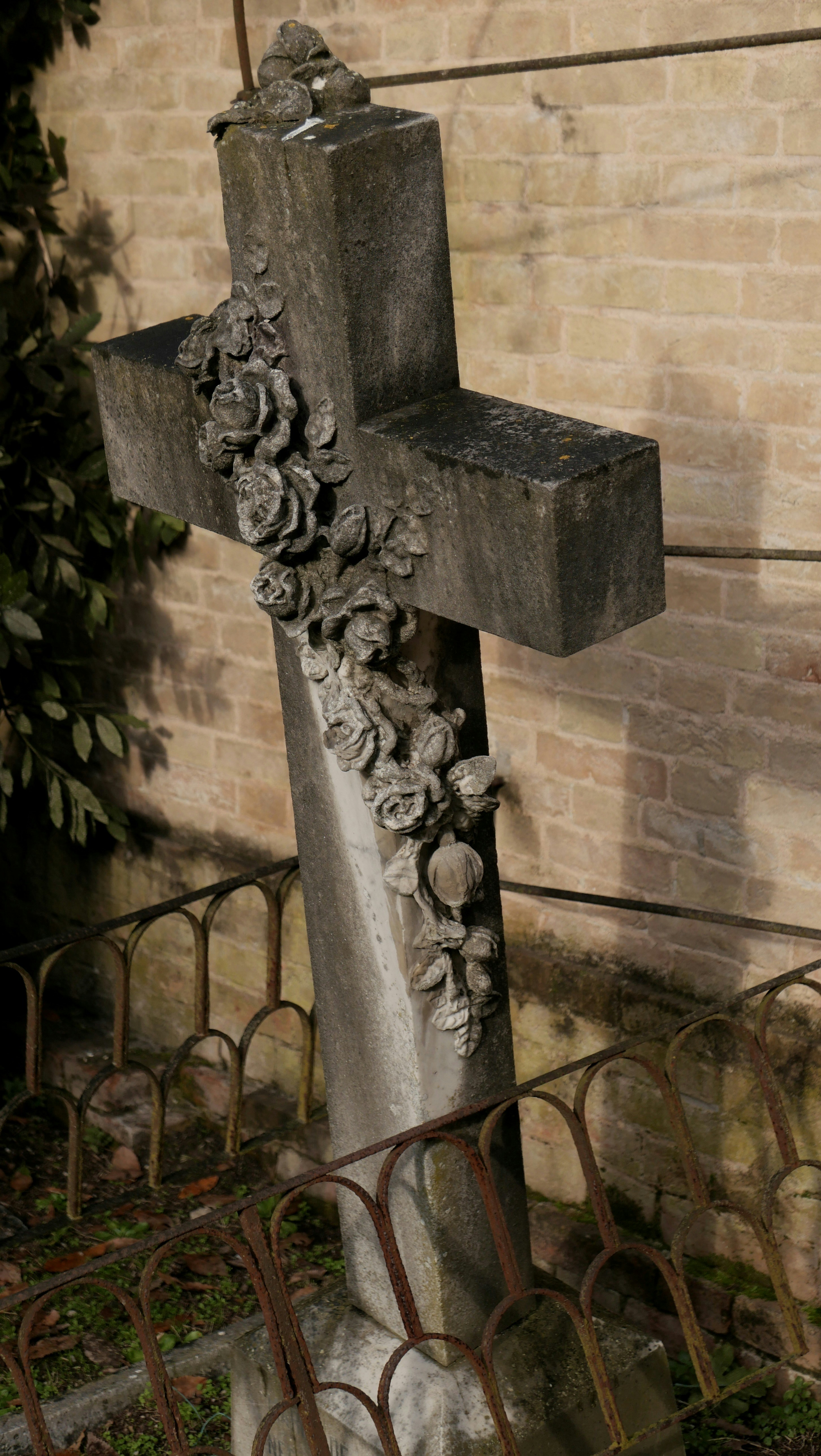 Weathered Cross Entwined with Roses in a Garden Gate