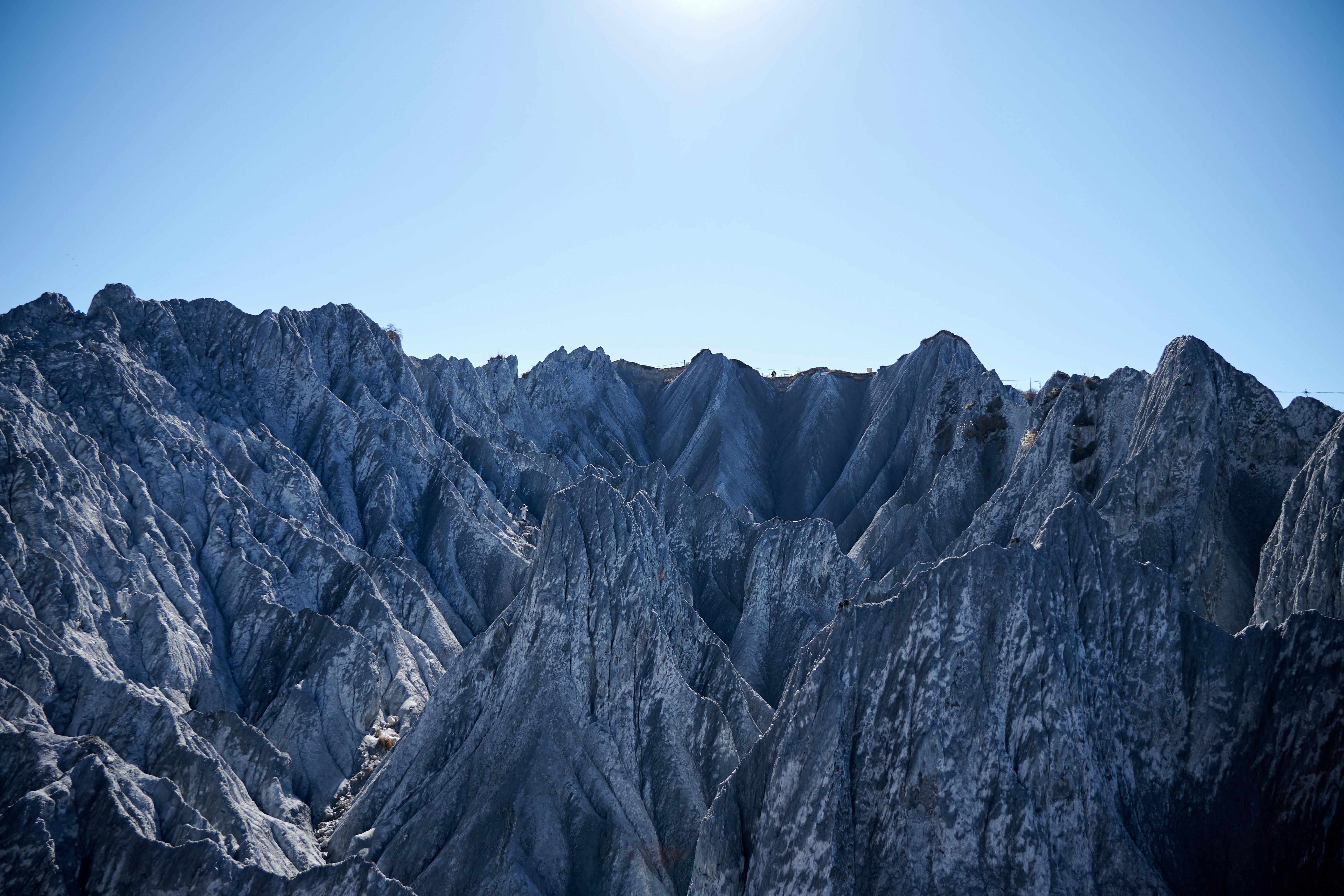 Rugged Crestscape: Sunlit Peaks Carved by Time