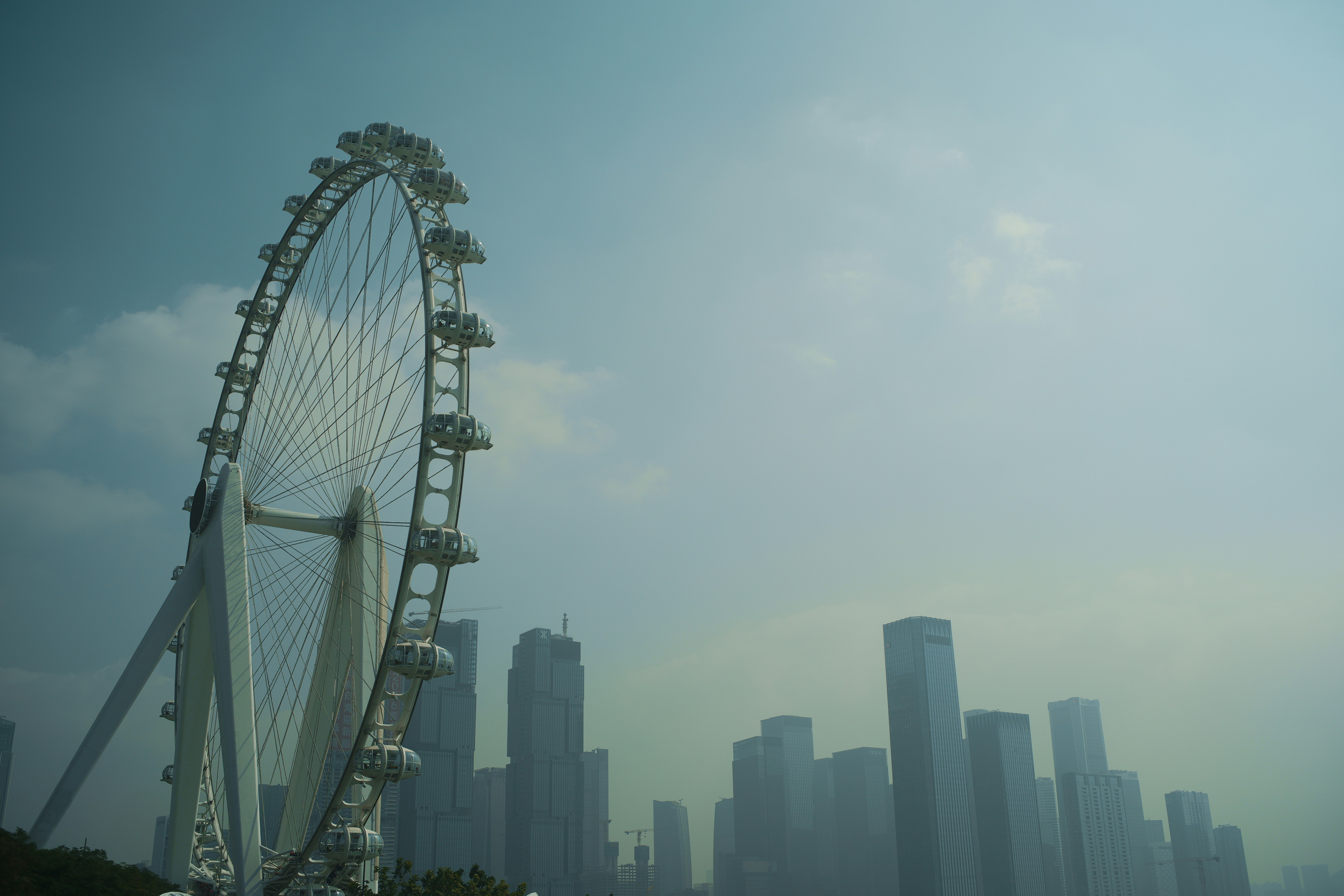 Nightfall Over the Ferris Wheel: A Cityscape in Soft Haze