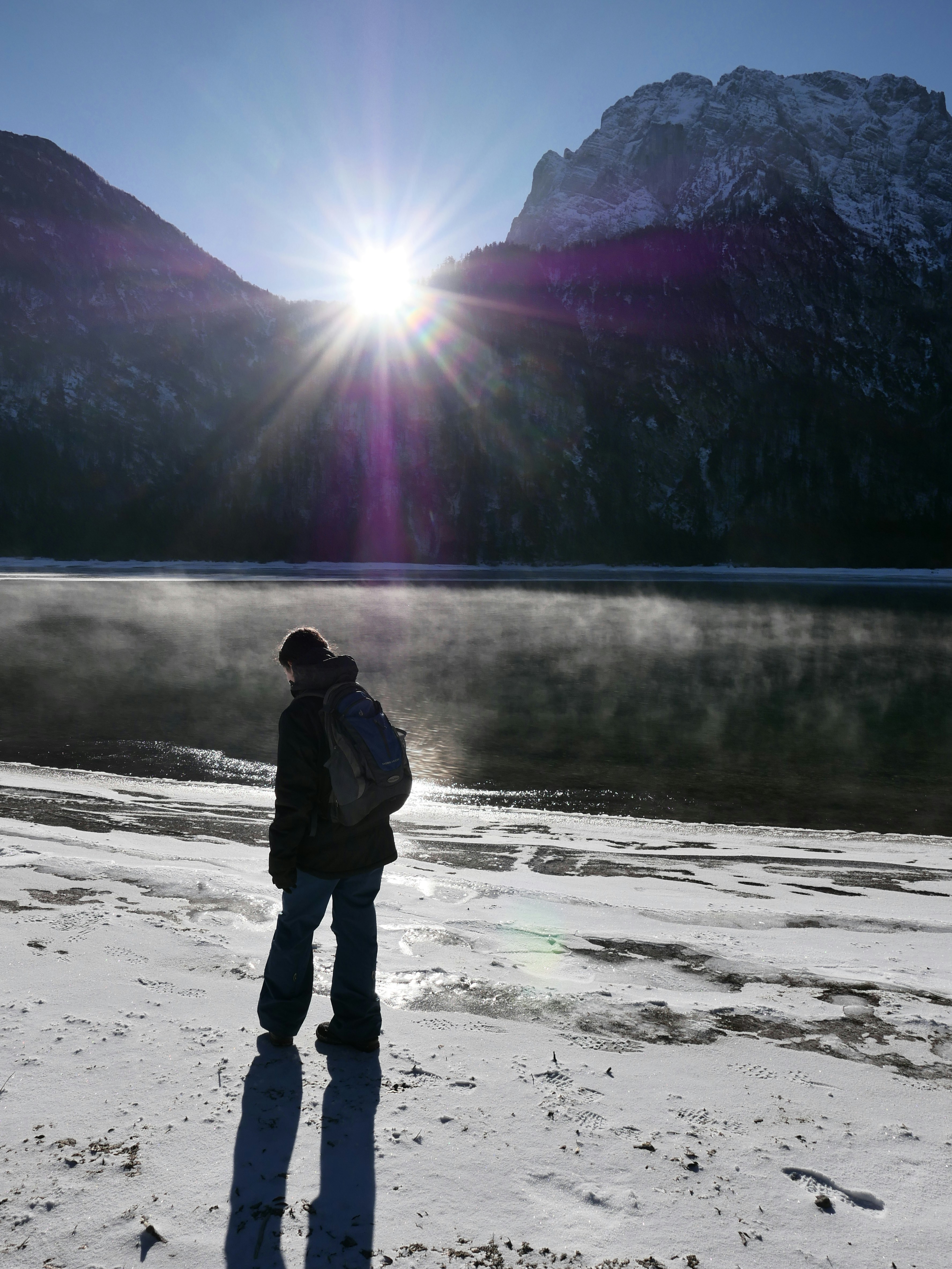 Sunlit Shore: A Lone Traveler at the Frozen Lake