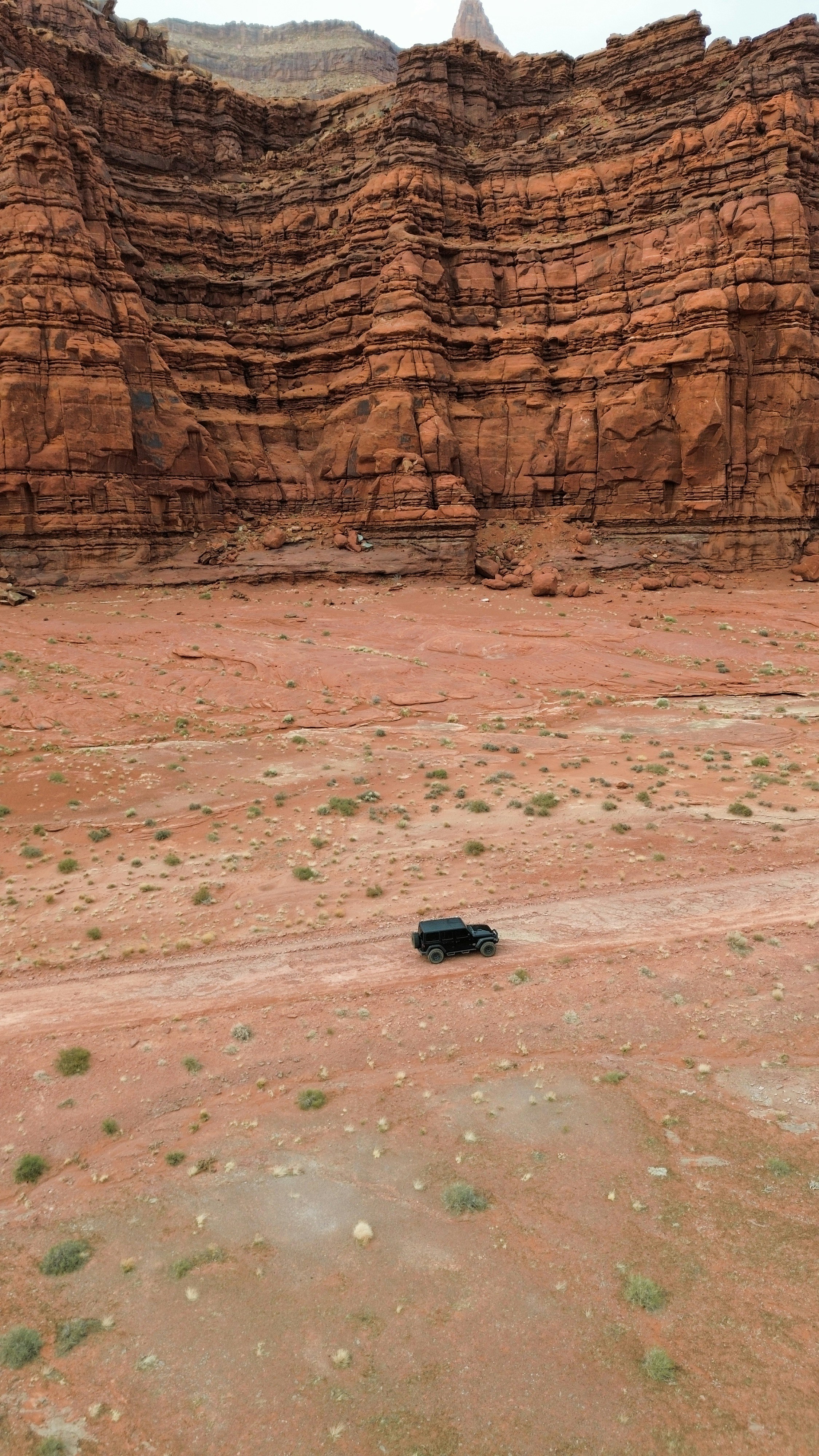 Desert Canyon Overlook: A Lone Jeep Beneath Canyon Walls