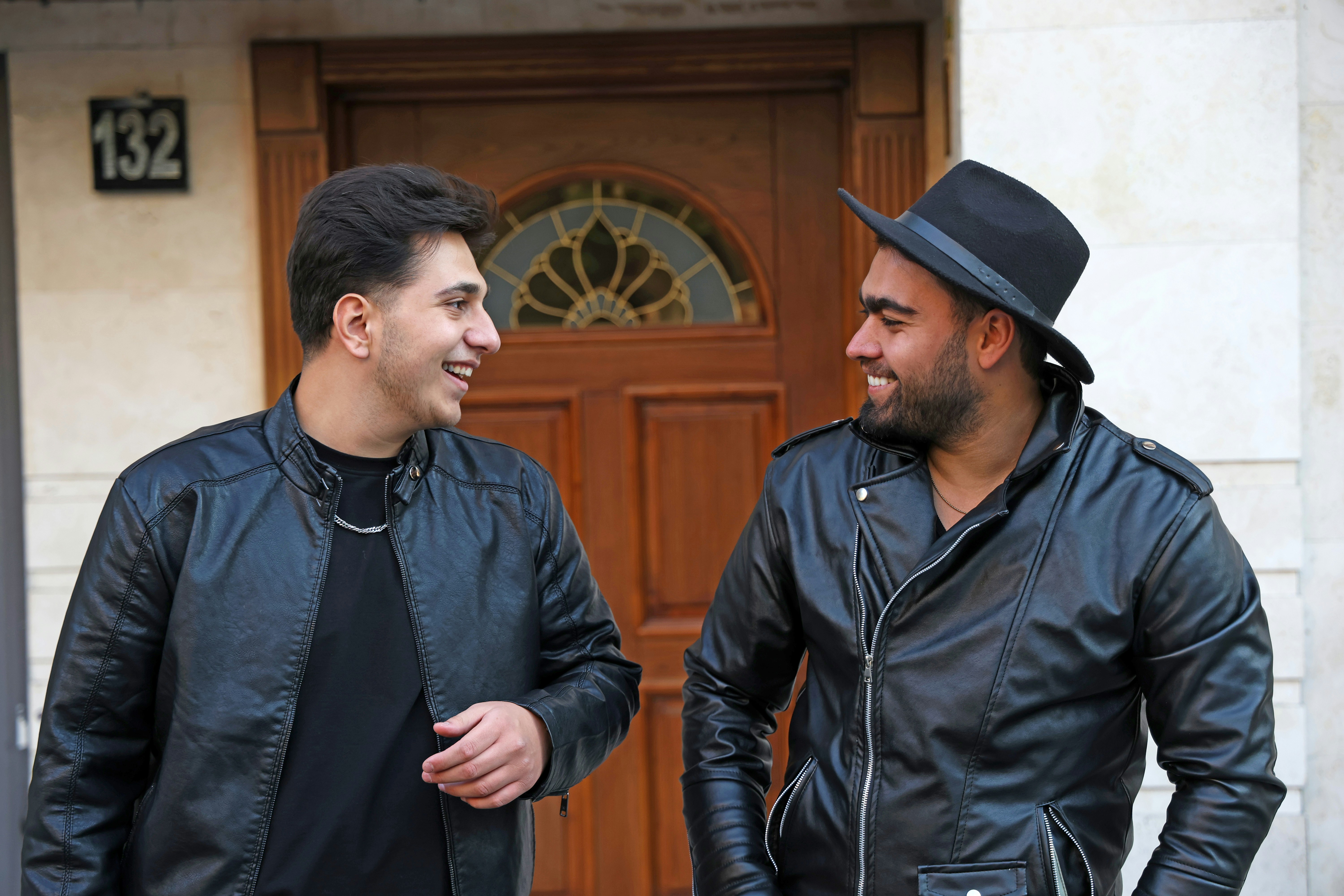 Two men in leather jackets talking outside photo – Free Friends Image ...