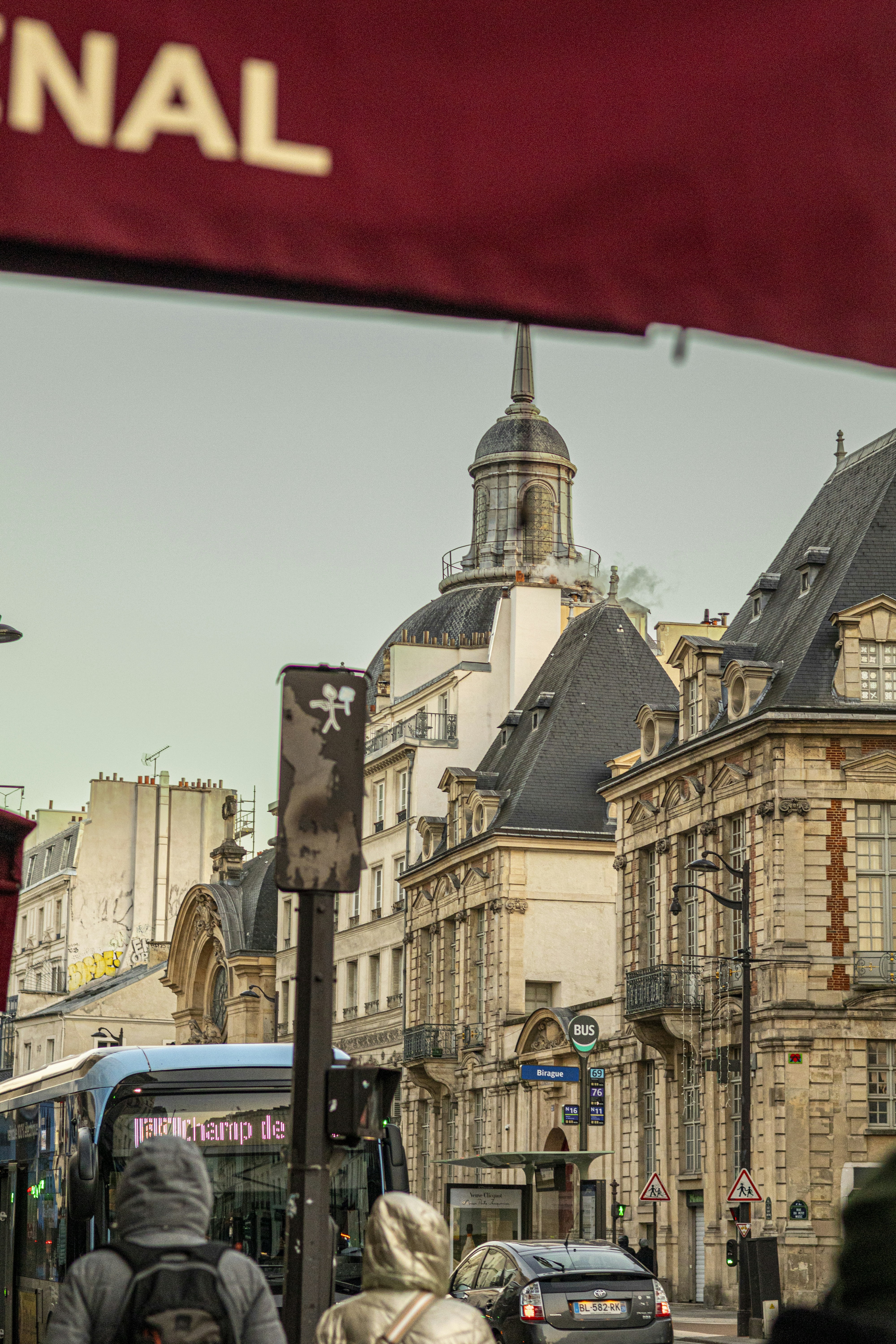 City Street in Paris: A Bus, Architecture, and a Red Overhang