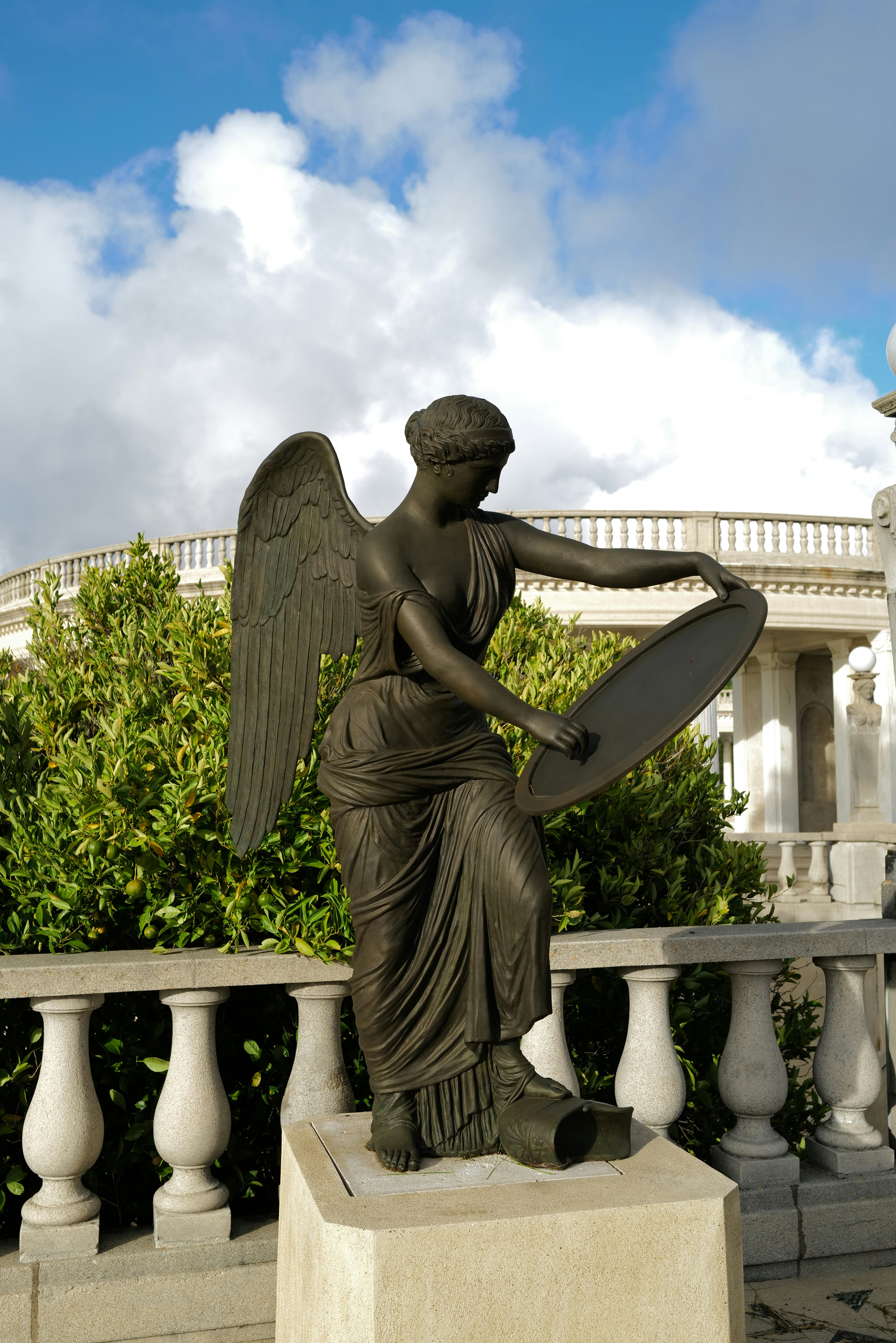 Winged Sentinel: Bronze Angel with Shield at a Classical Terrace