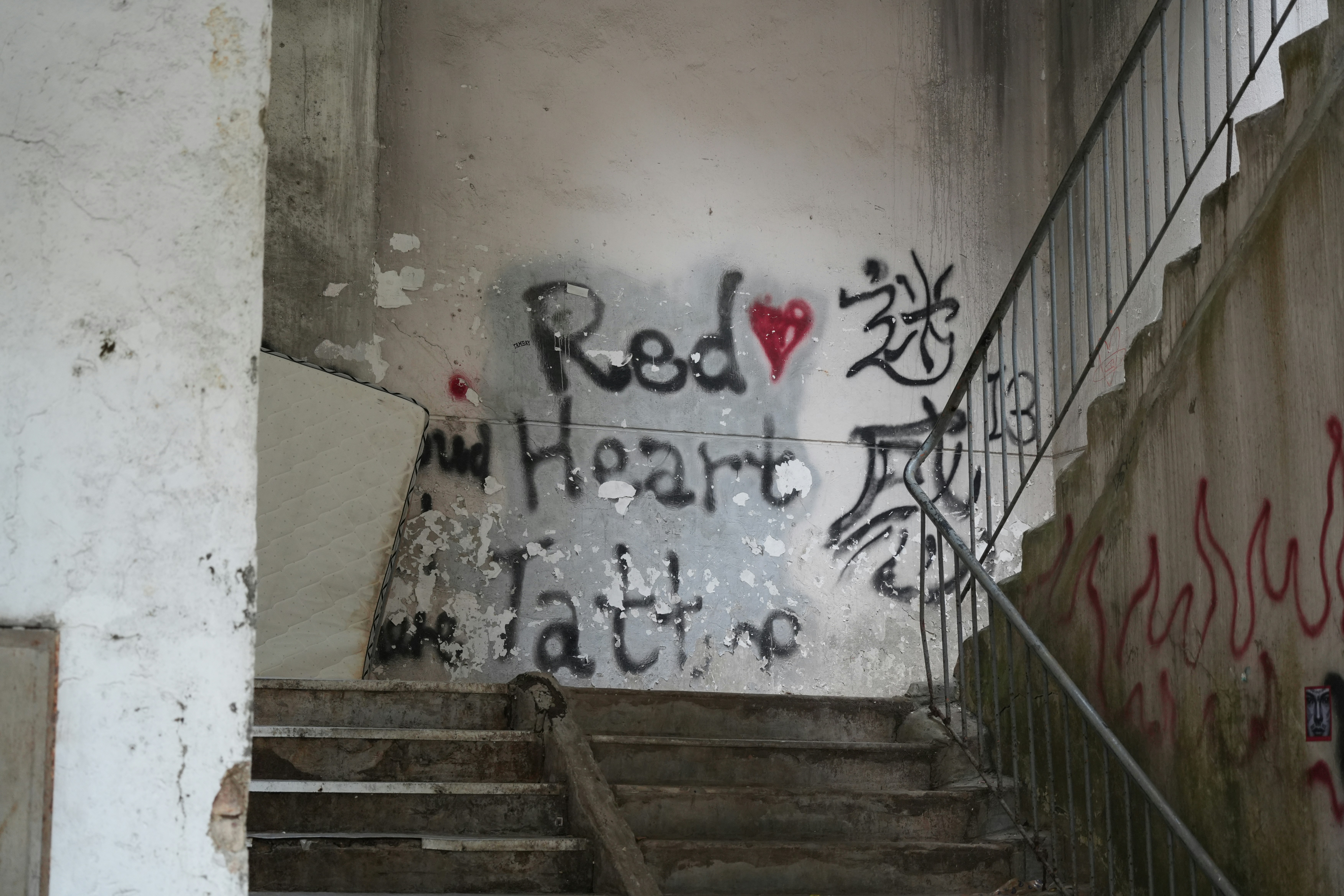 Graffiti Staircase: Weathered Messages on a Faded Wall