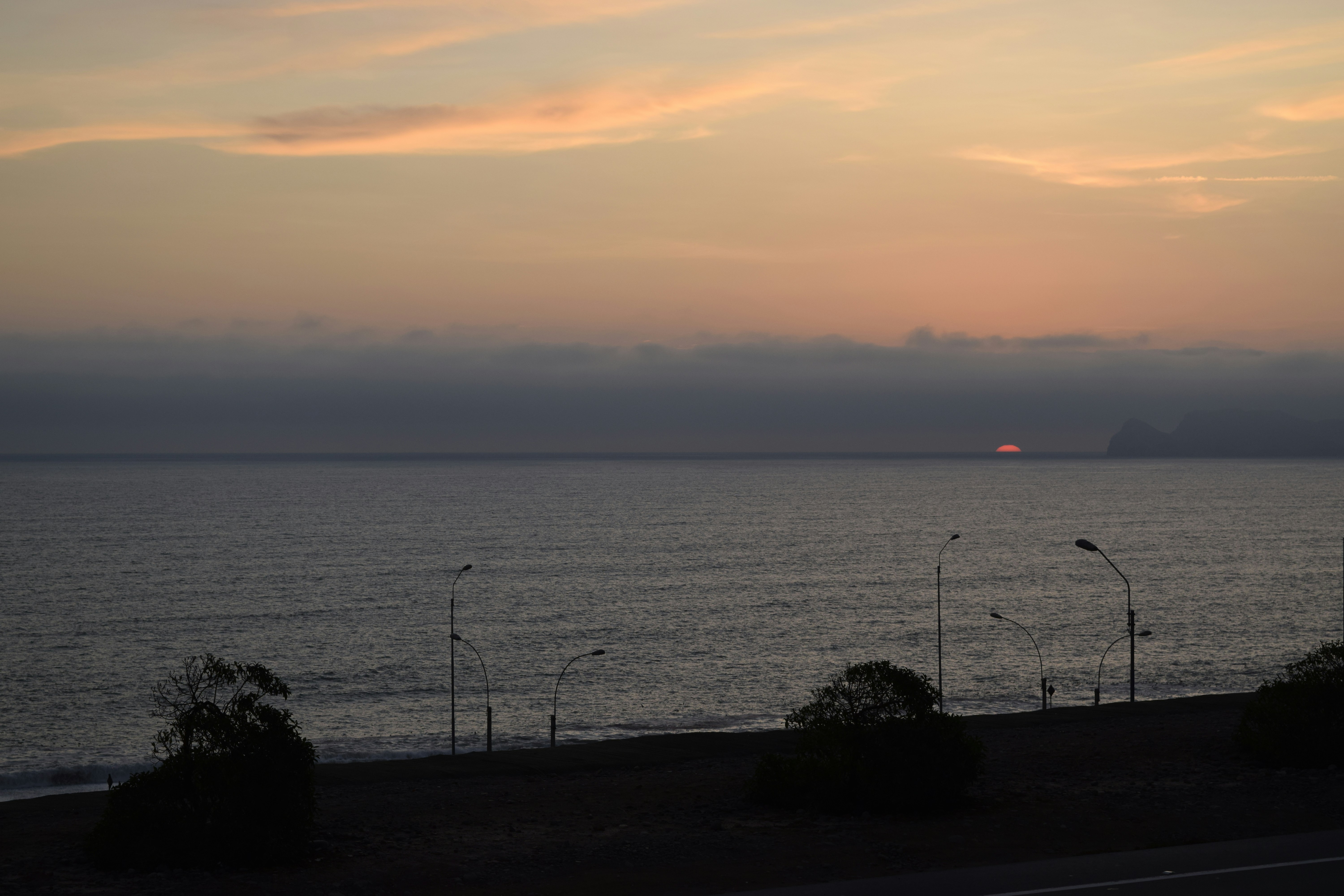 Sunset Over Quiet Sea: Dusk Light on a Beachside Road