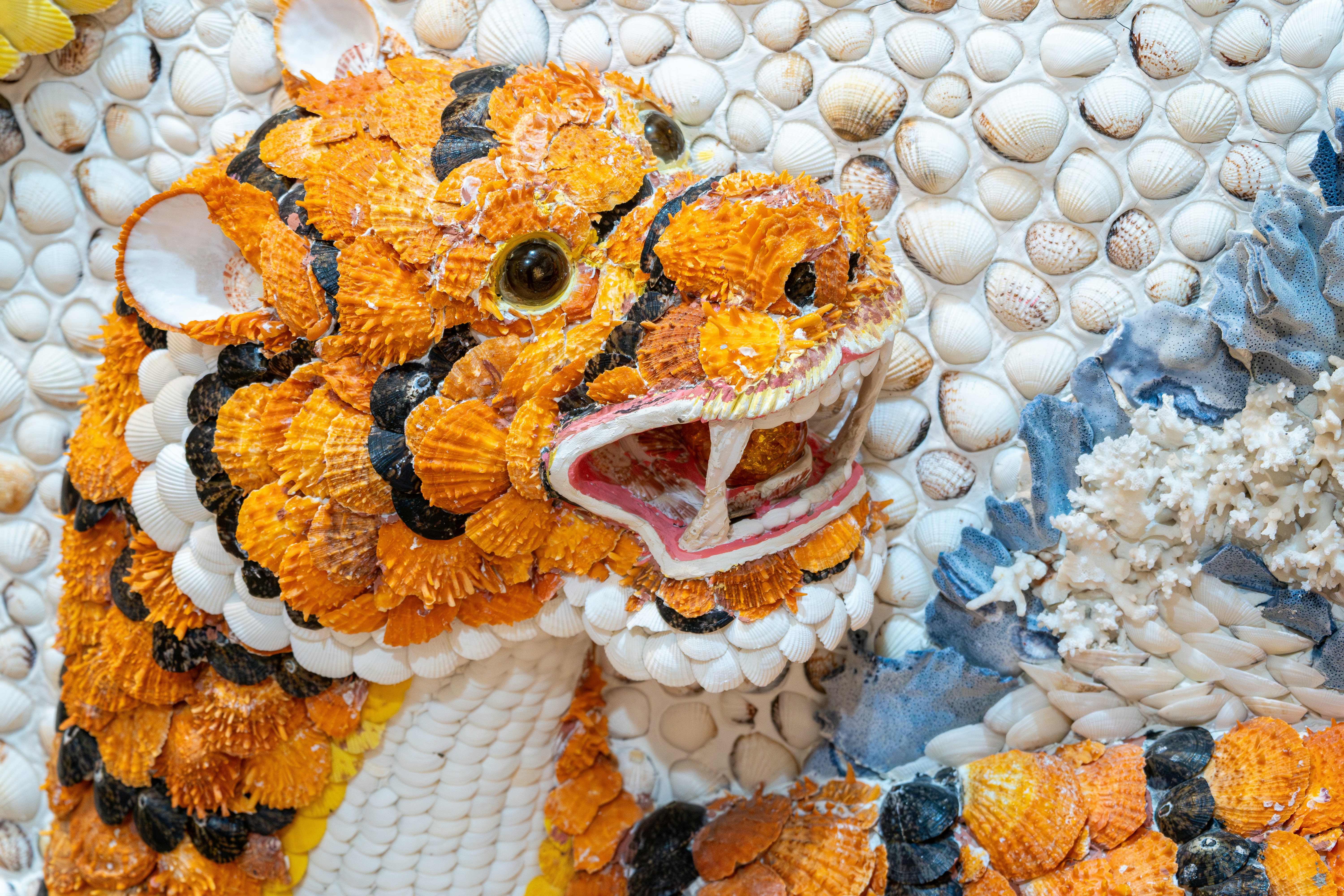 Mosaic of Scales: A Colorful Dragon's Head Emerges from Pebbled Sea