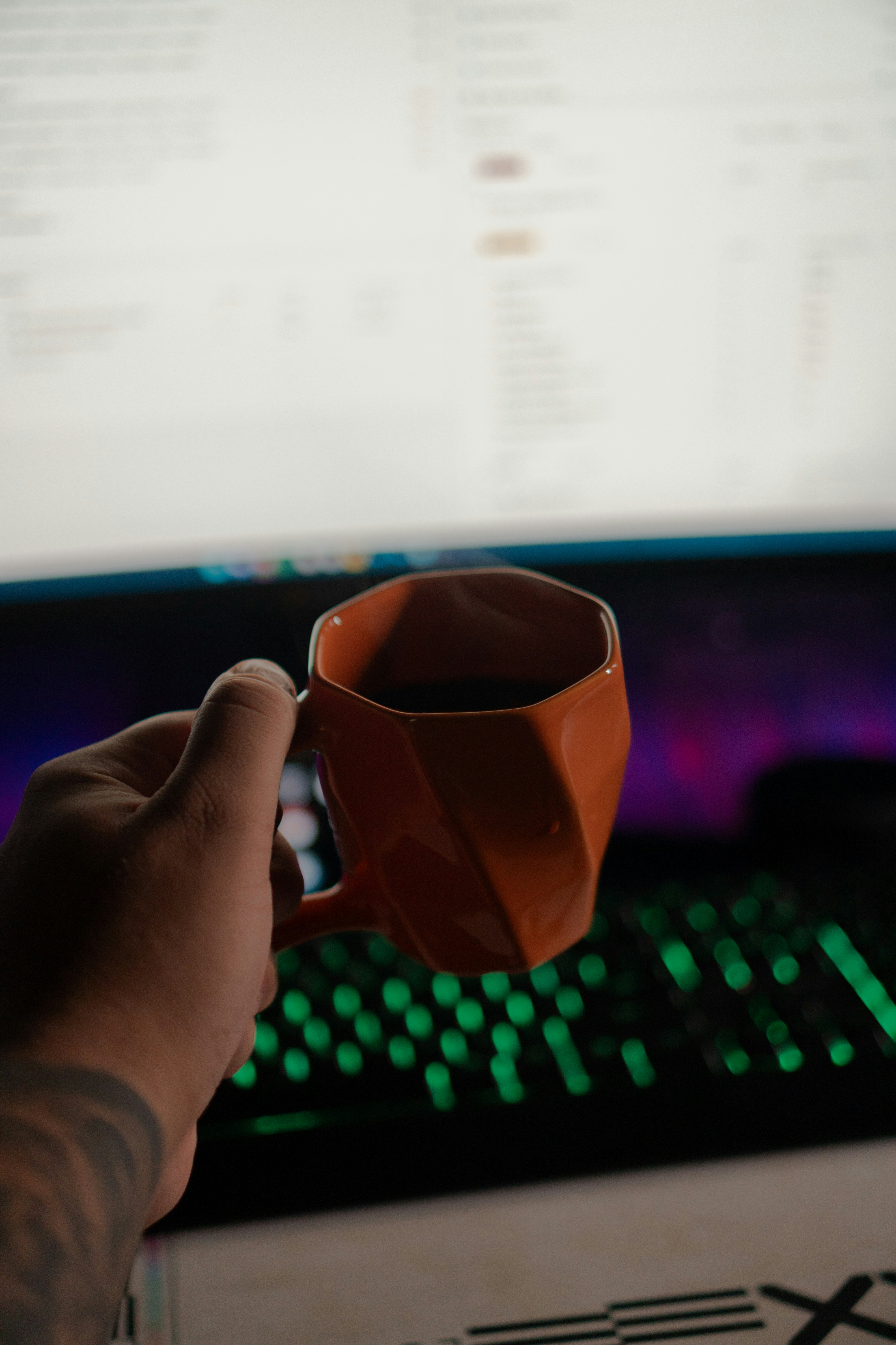 Holding a Ceramic Coffee Cup in Front of a Backlit Keyboard