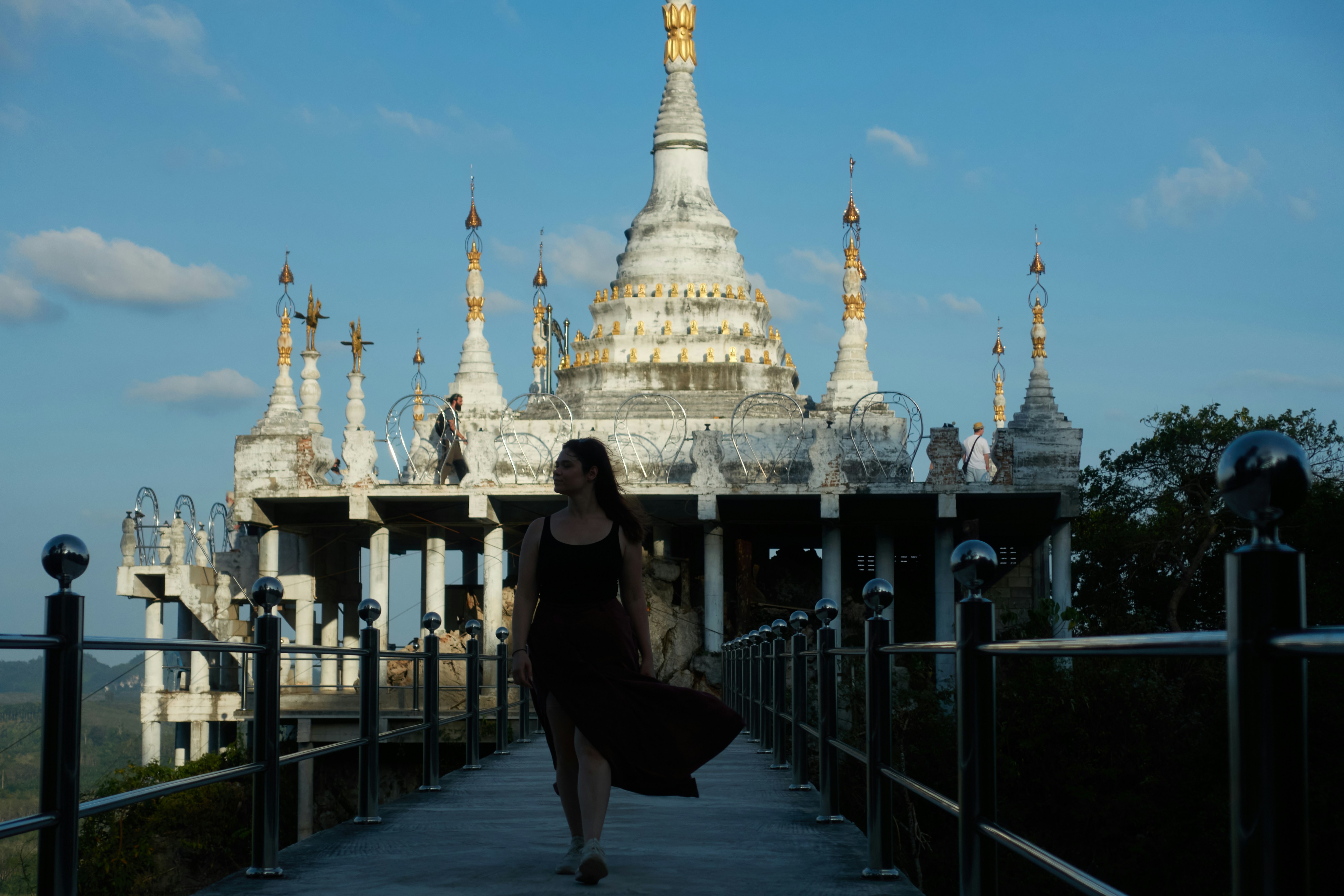 Silhouette on a Temple Bridge: A Quiet Walk Beneath Spires