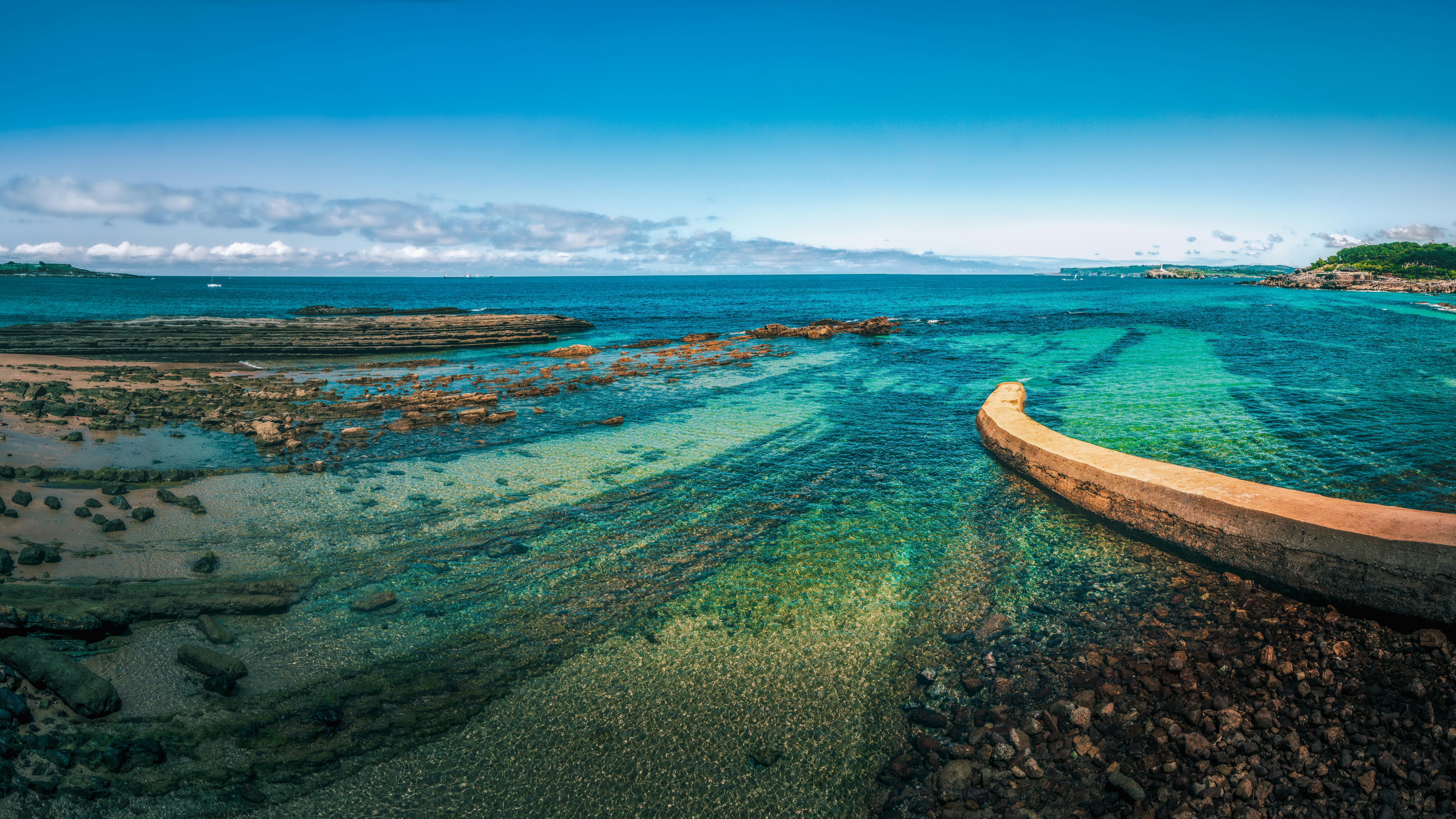 Azure tile of sea and sky over a rocky shoreline