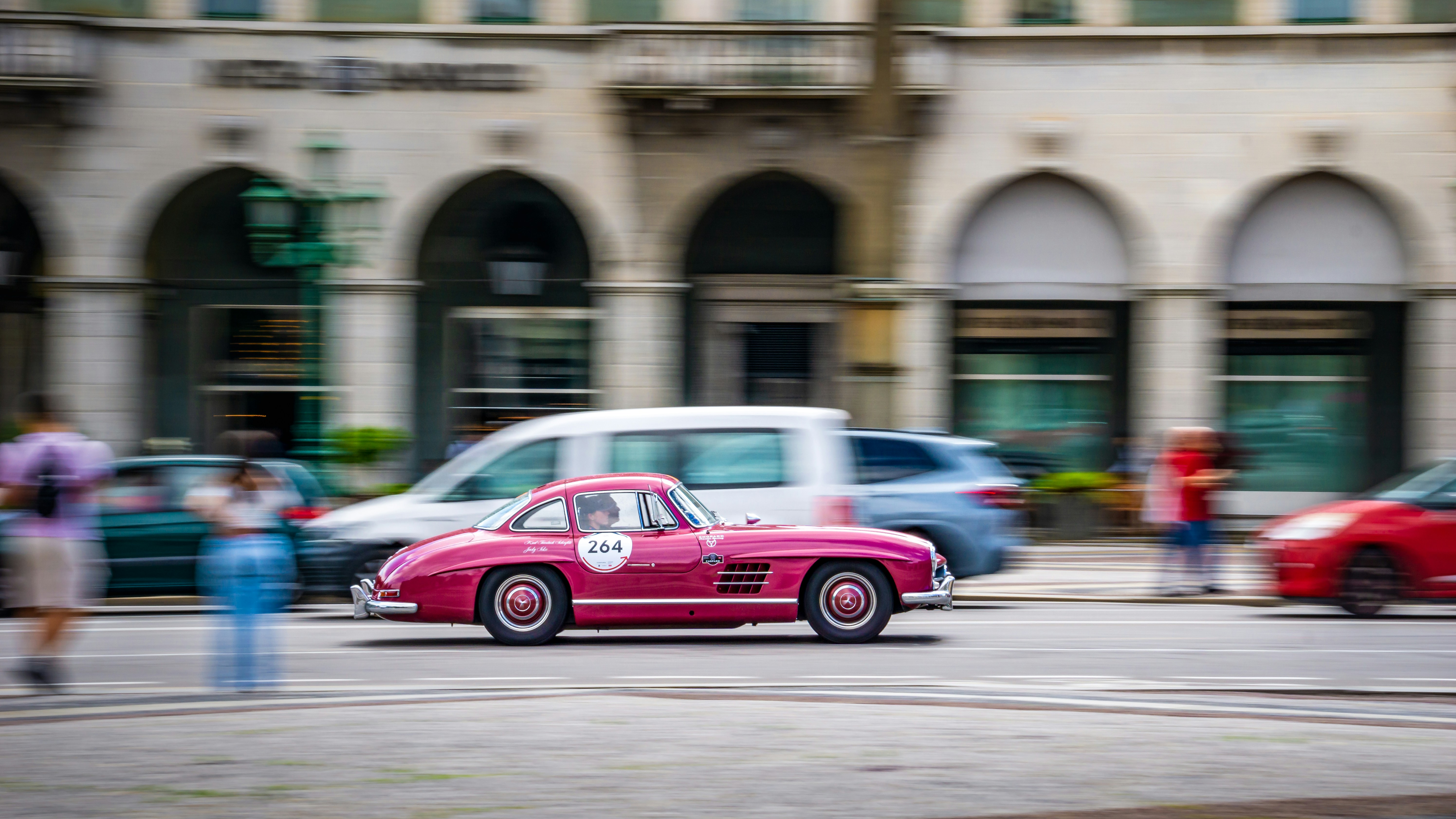 Chrome-on-Quarters: A Vintage Pink Sedan Halts Traffic in a European Square