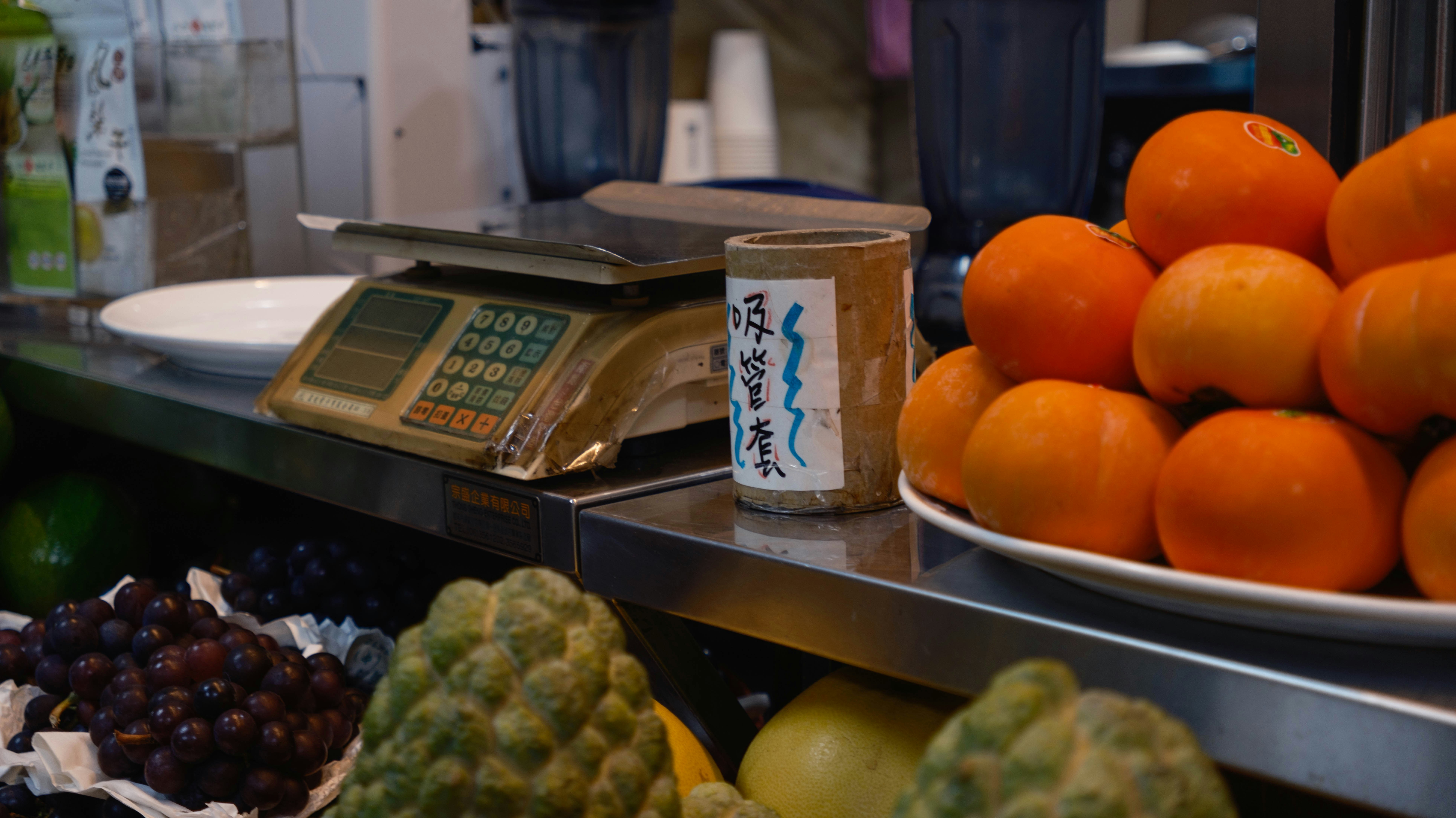 Orange Market Counter: Fresh Produce and Scale in a Busy Kitchen Stall
