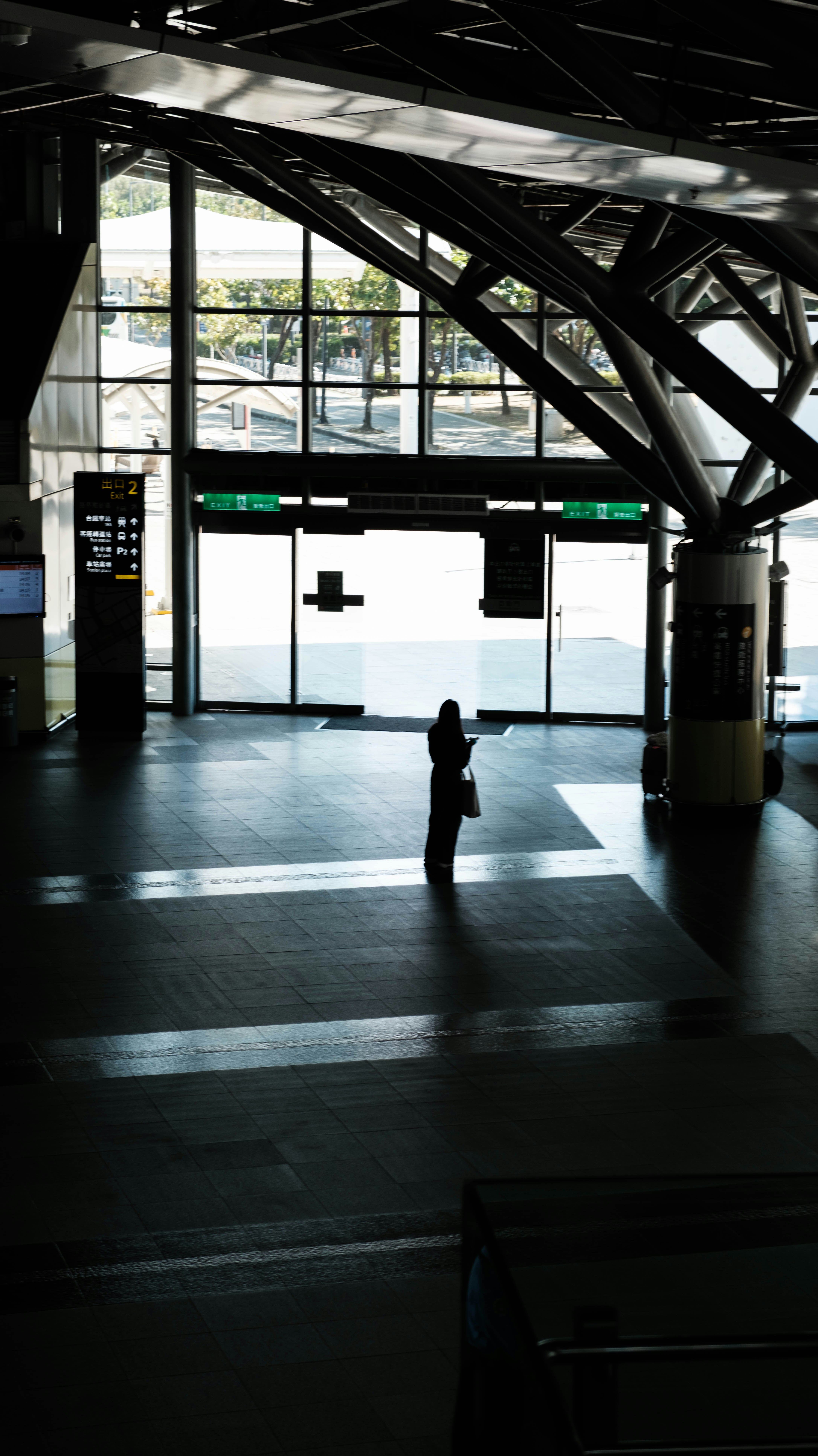 Silhouette at the Threshold: Solo Traveler in a Sunlit Transit Hall
