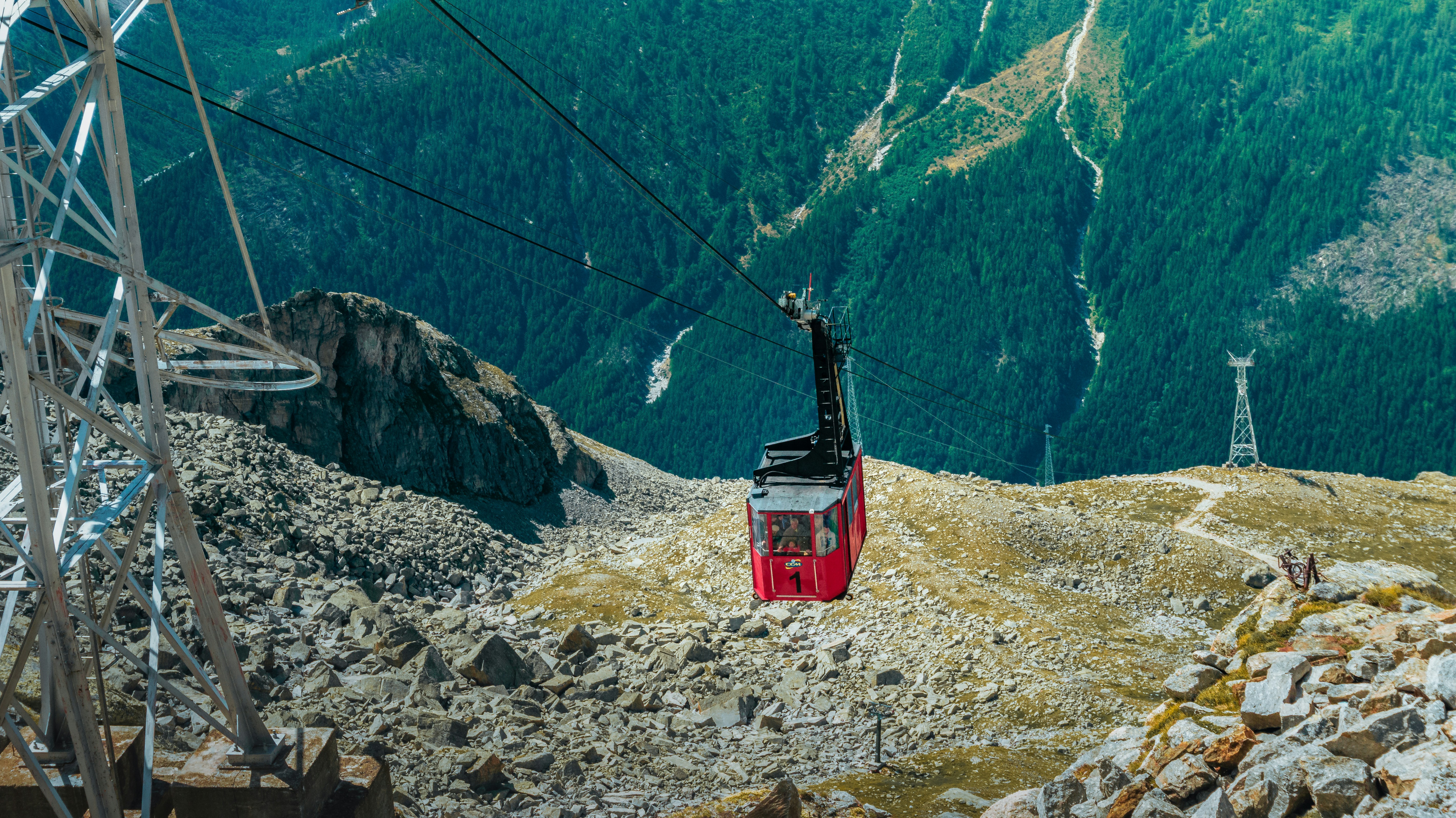 Red Cable Car Ascends a Rugged Alpine Chasm