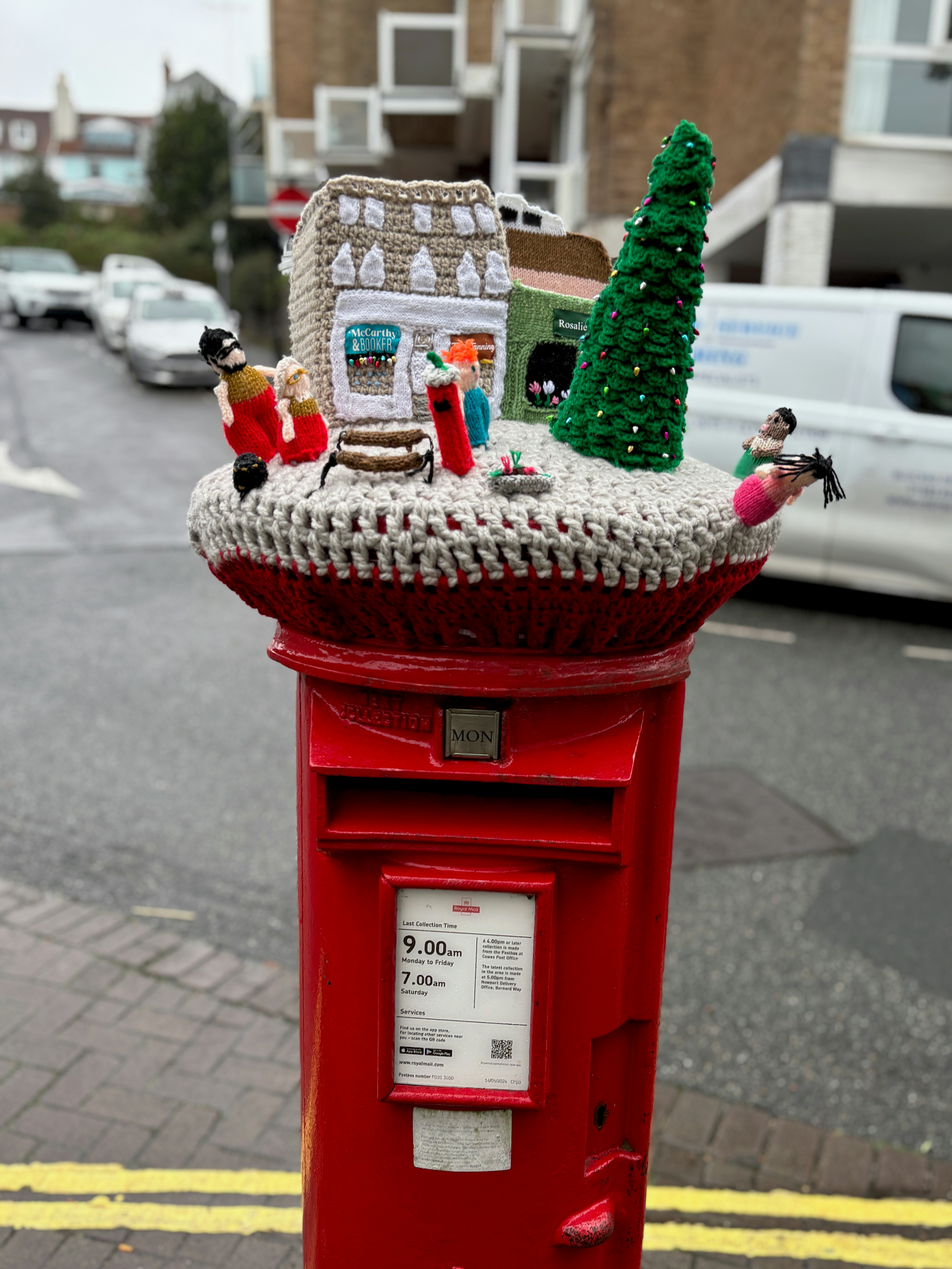 Festive Snow-Capped House Adorning a Red Postbox