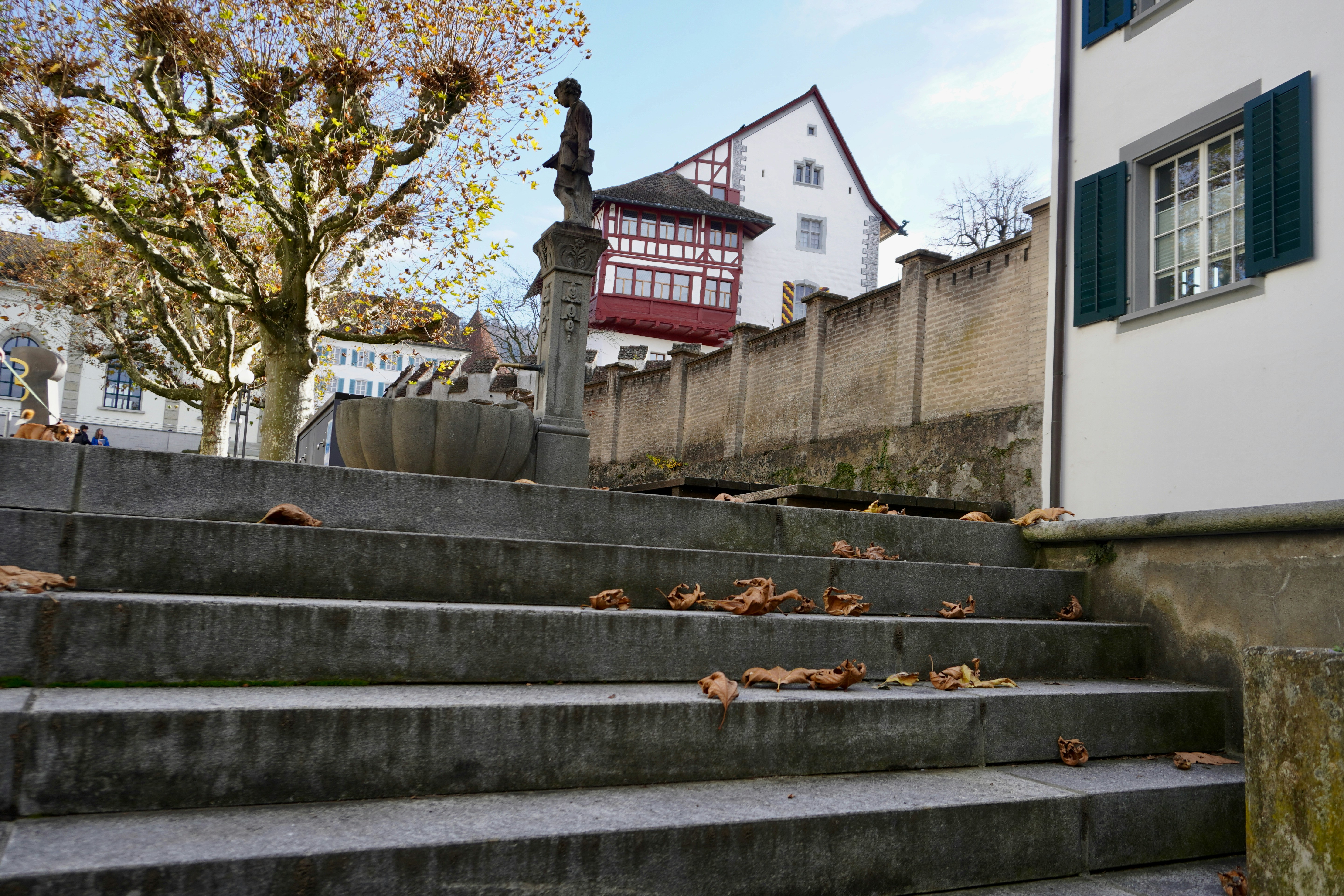 Staircase to a quaint townscape framed by a statue and rooftops