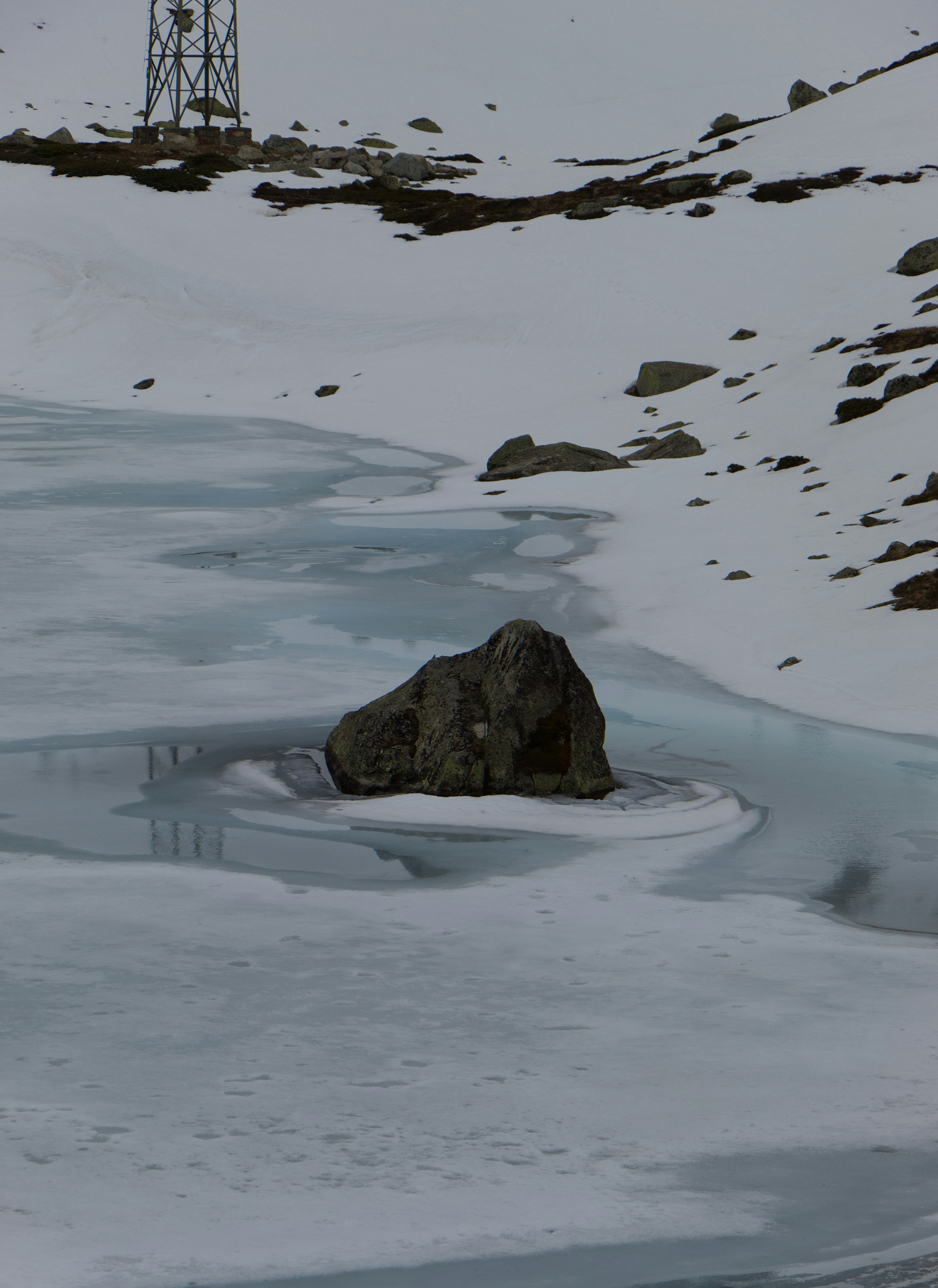 Frozen Sentinel: A lone rock guards a pale, glacial pool