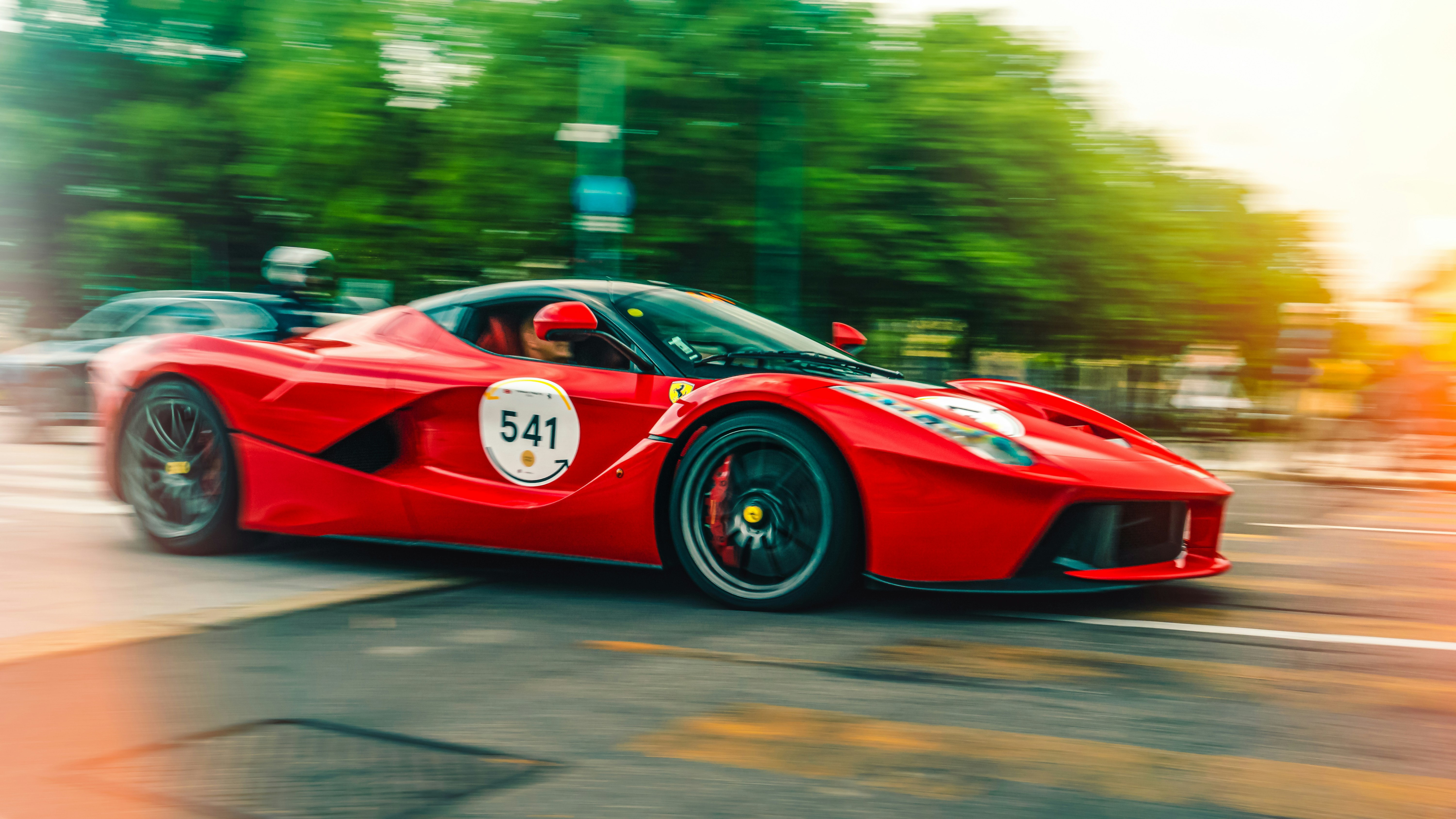 Red Fury in Motion: A Race-Bred Ferrari Speeds Past the Crowd