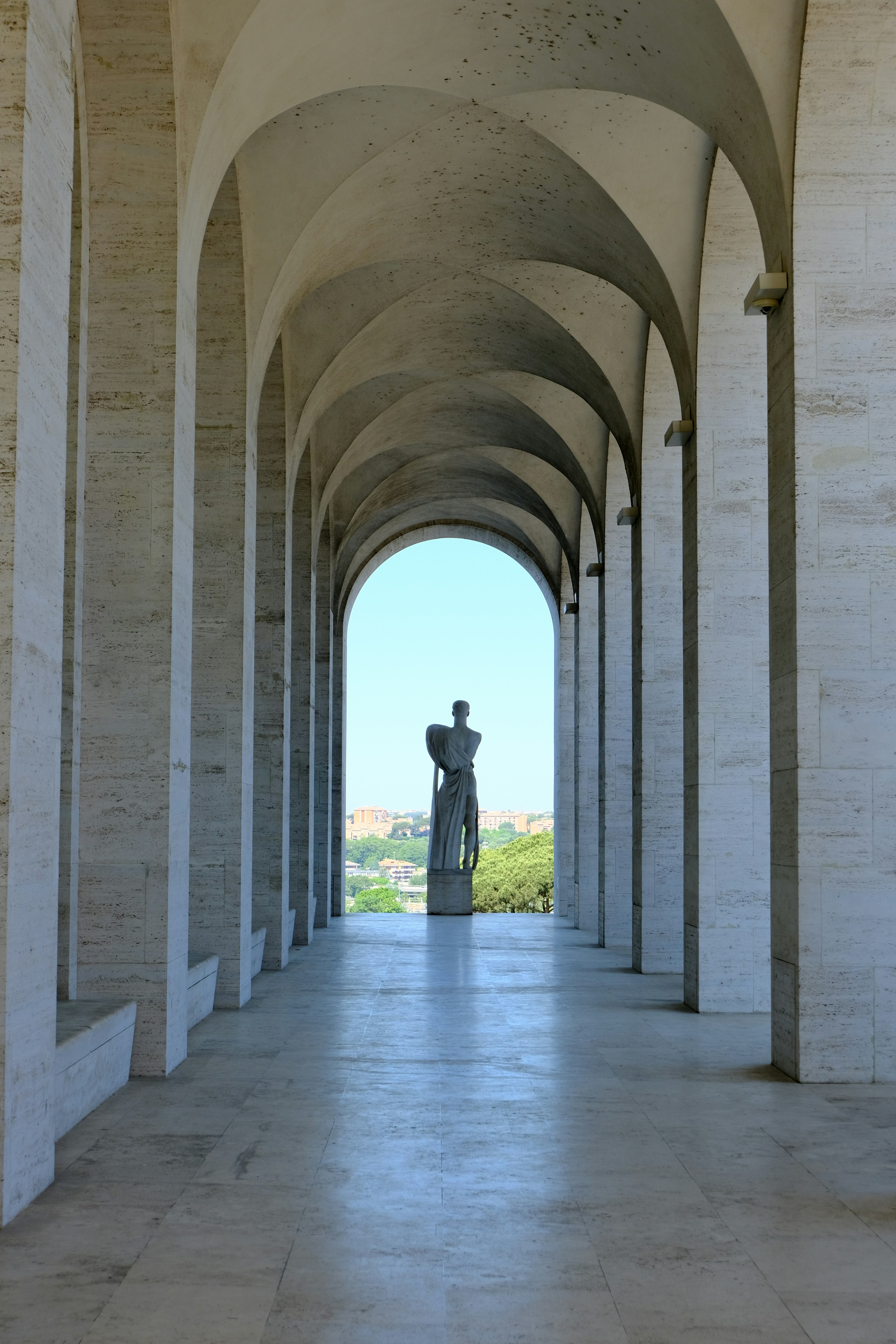 Archway Corridor to the Horizon: A Quiet Transit to the Statue