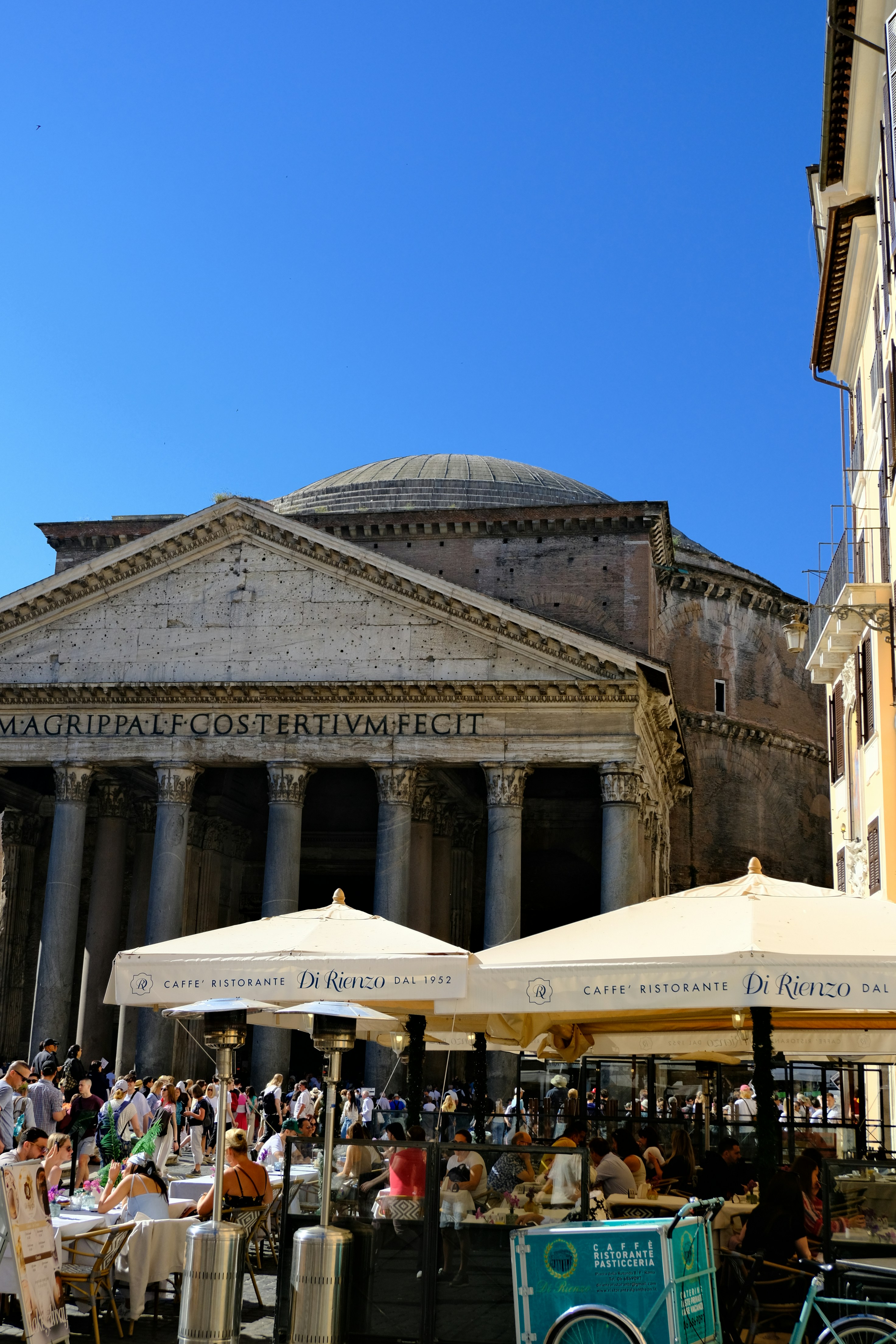 Temple Facade Rising Over a Lively Café Terrace in Piazza