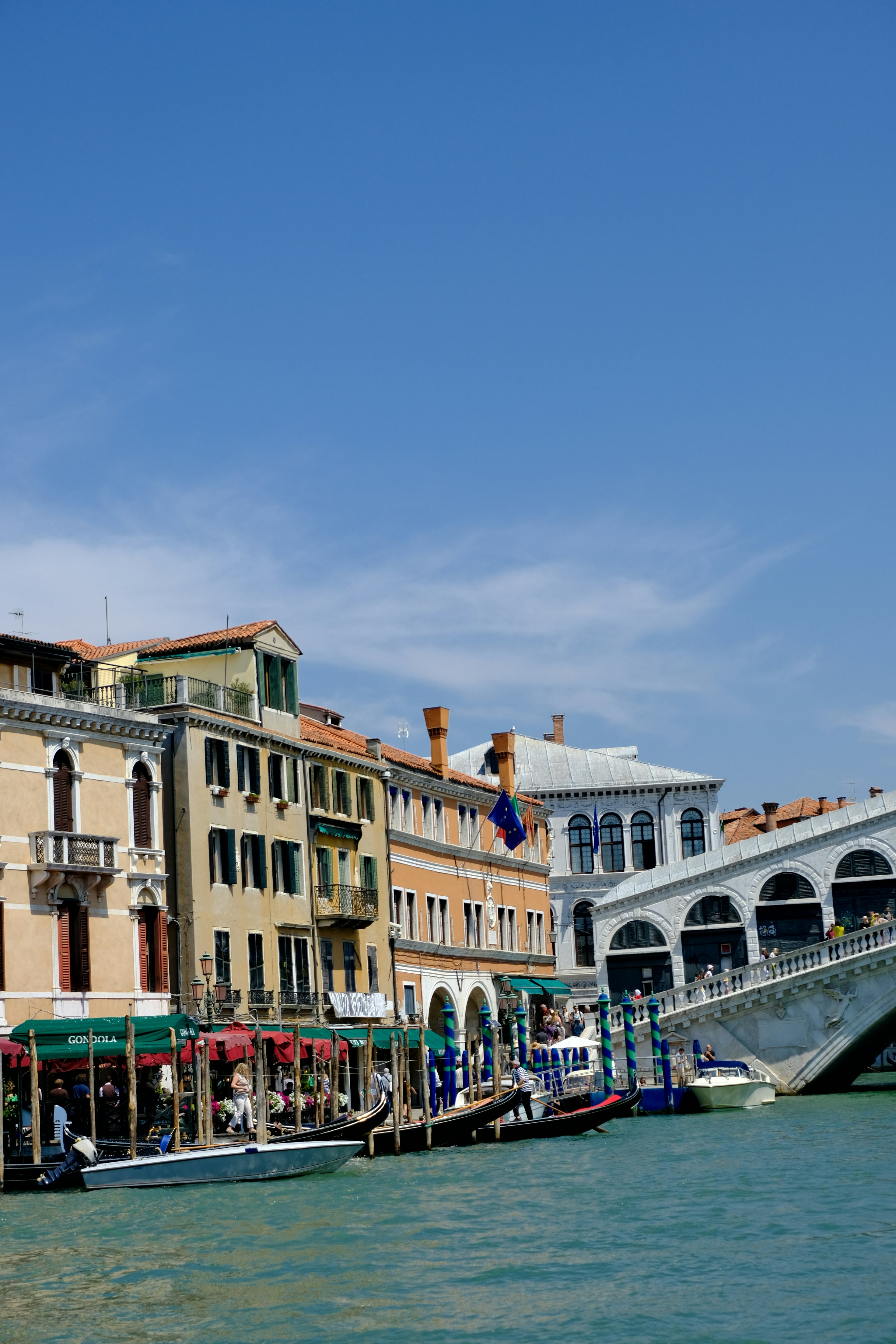 Venetian Canalfront: Boats Lined Up Under A Colorful Arc of Buildings