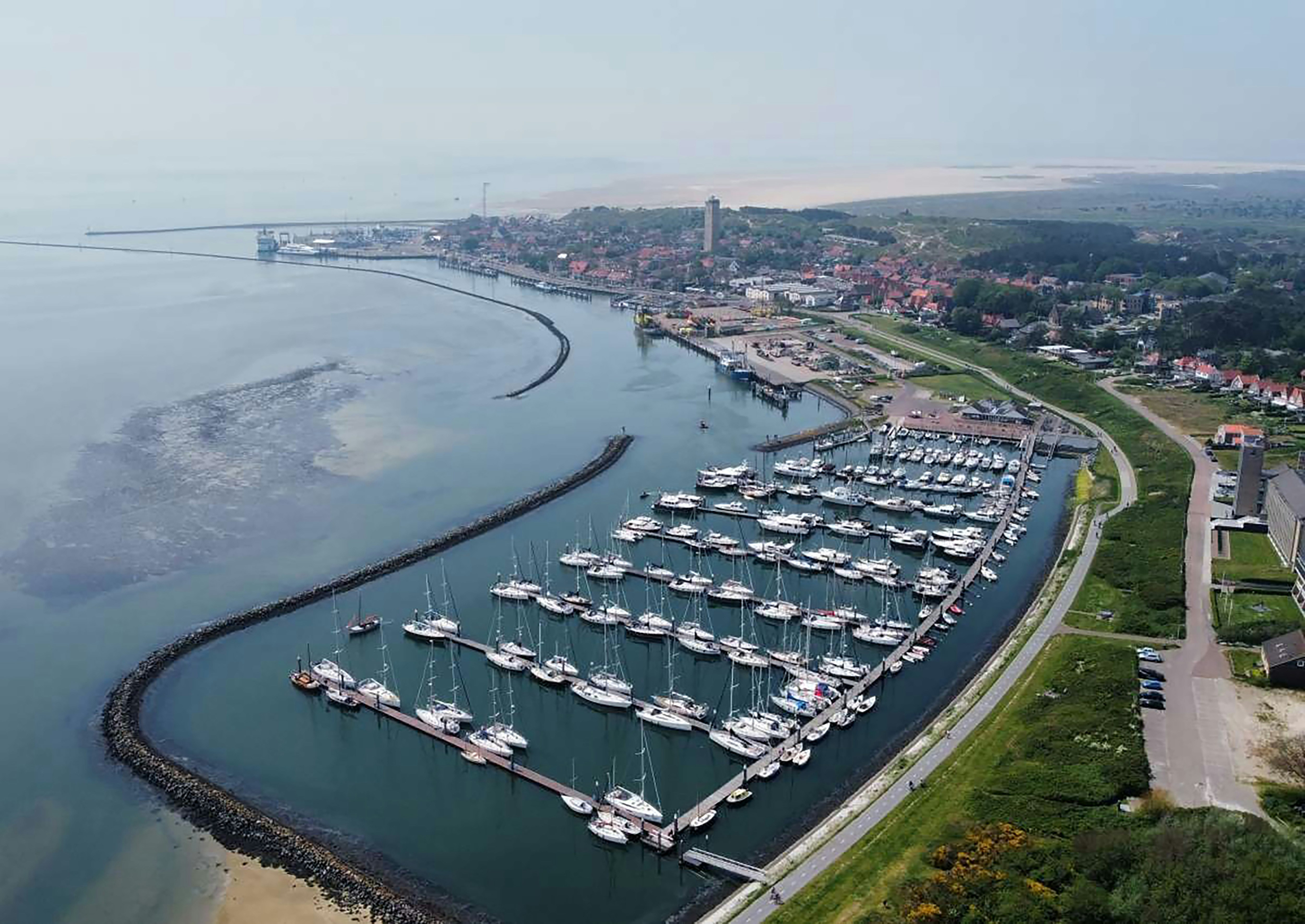 Boats docked in a marina with coastal town background photo – Free ...