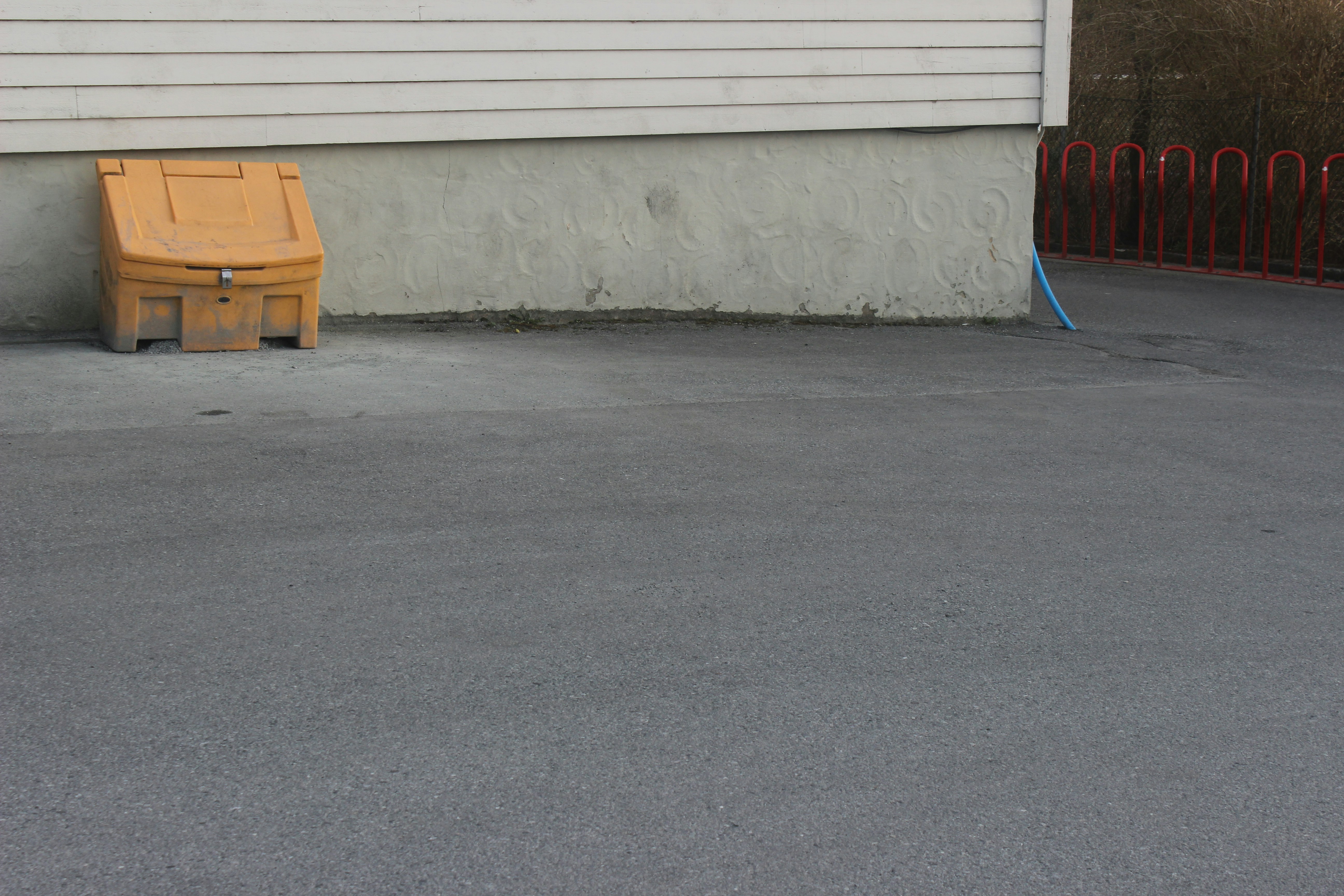 Orange Container at the Base of a Building