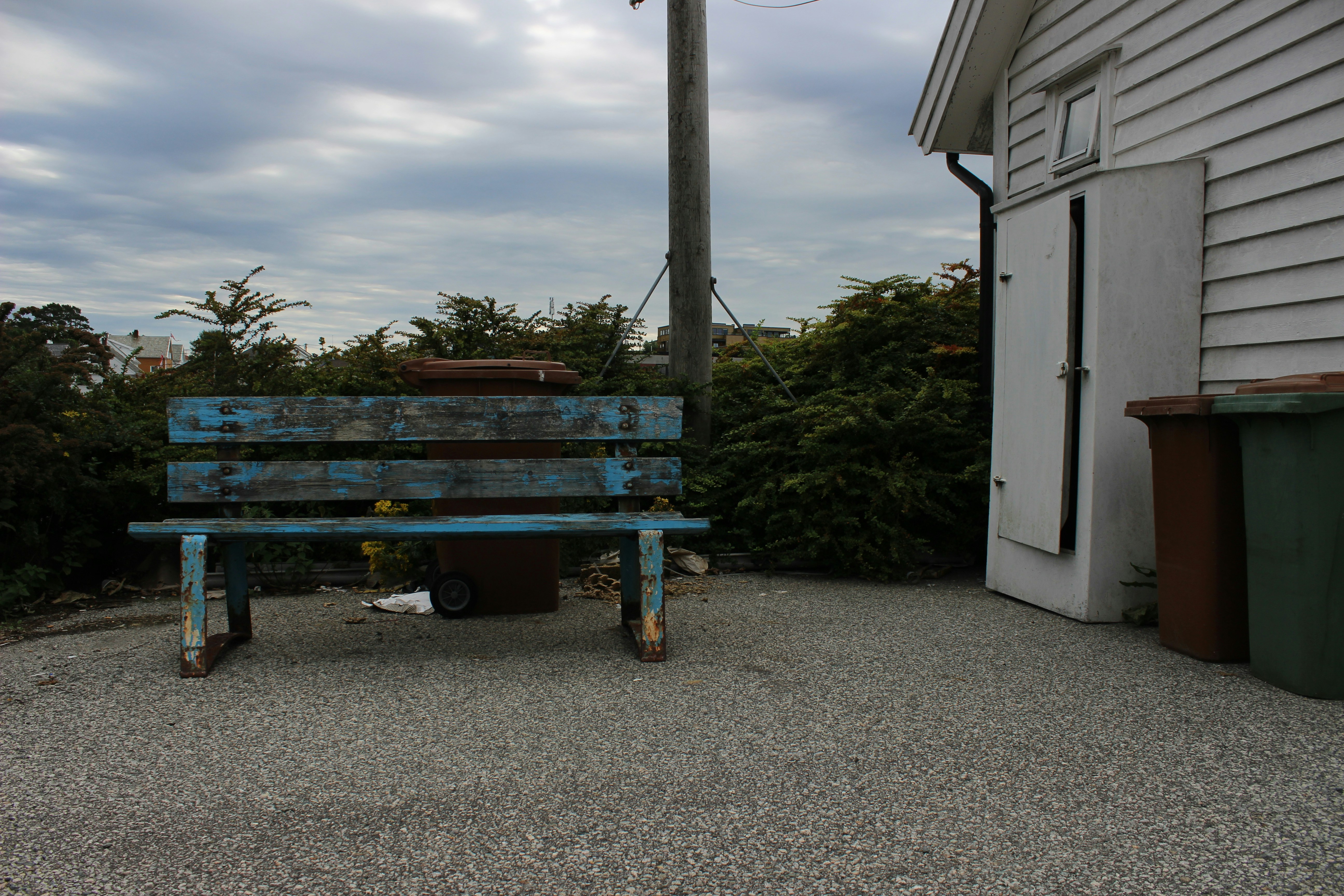 A Weathered Blue Bench at the Edge of Quiet Grounds