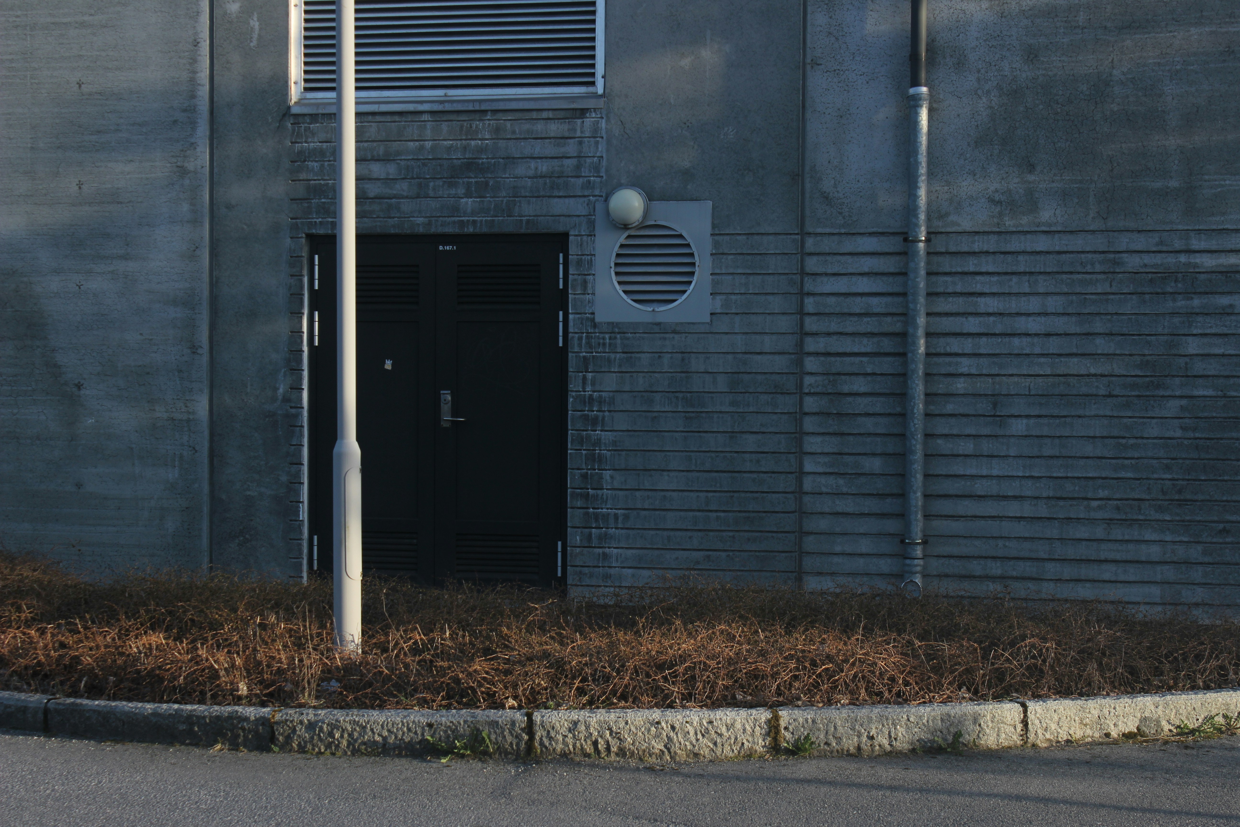 Hidden doorway under muted blue facade
